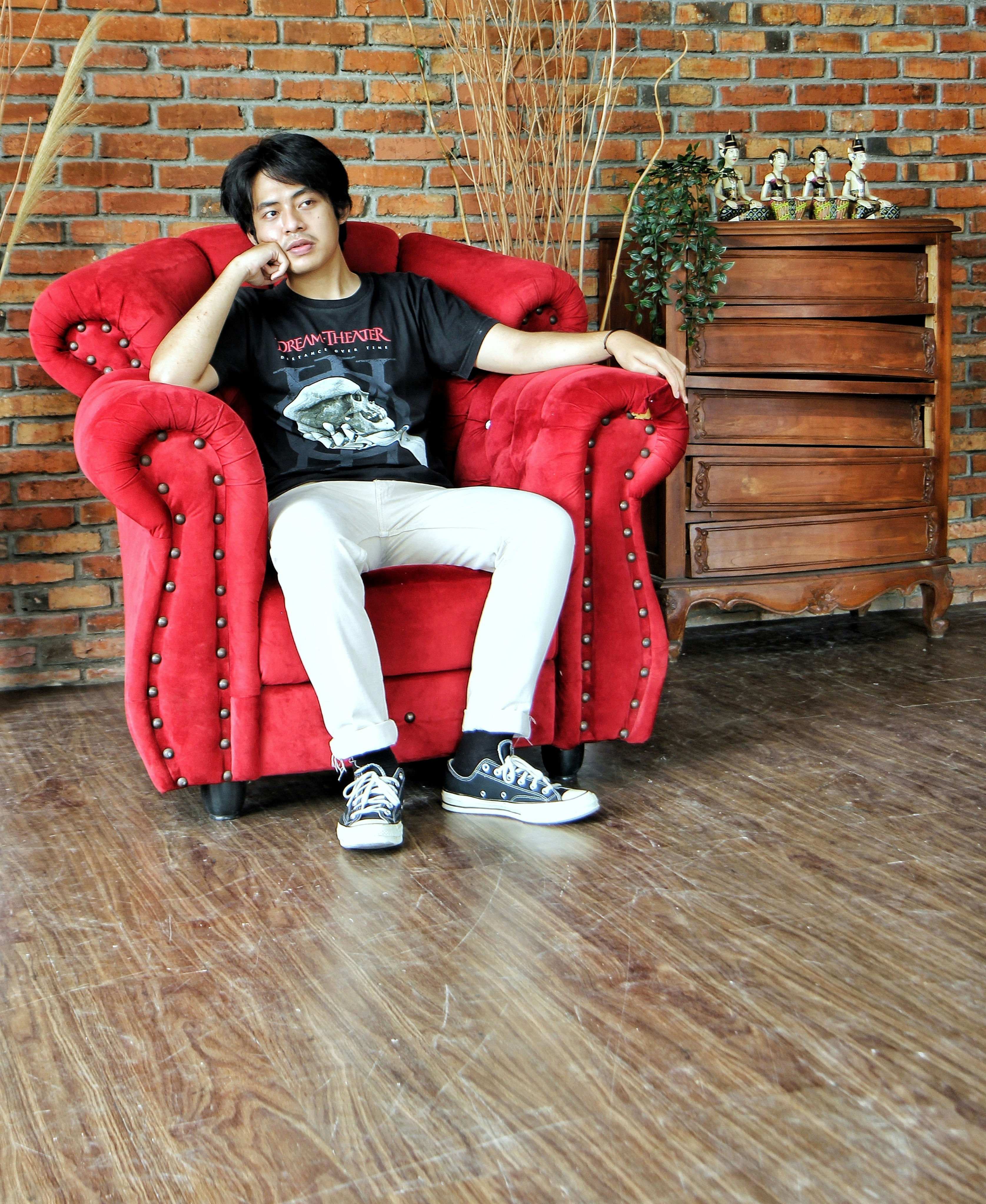Red Velvet Armchair Calm: A Youthful Moment in a Brick Studio