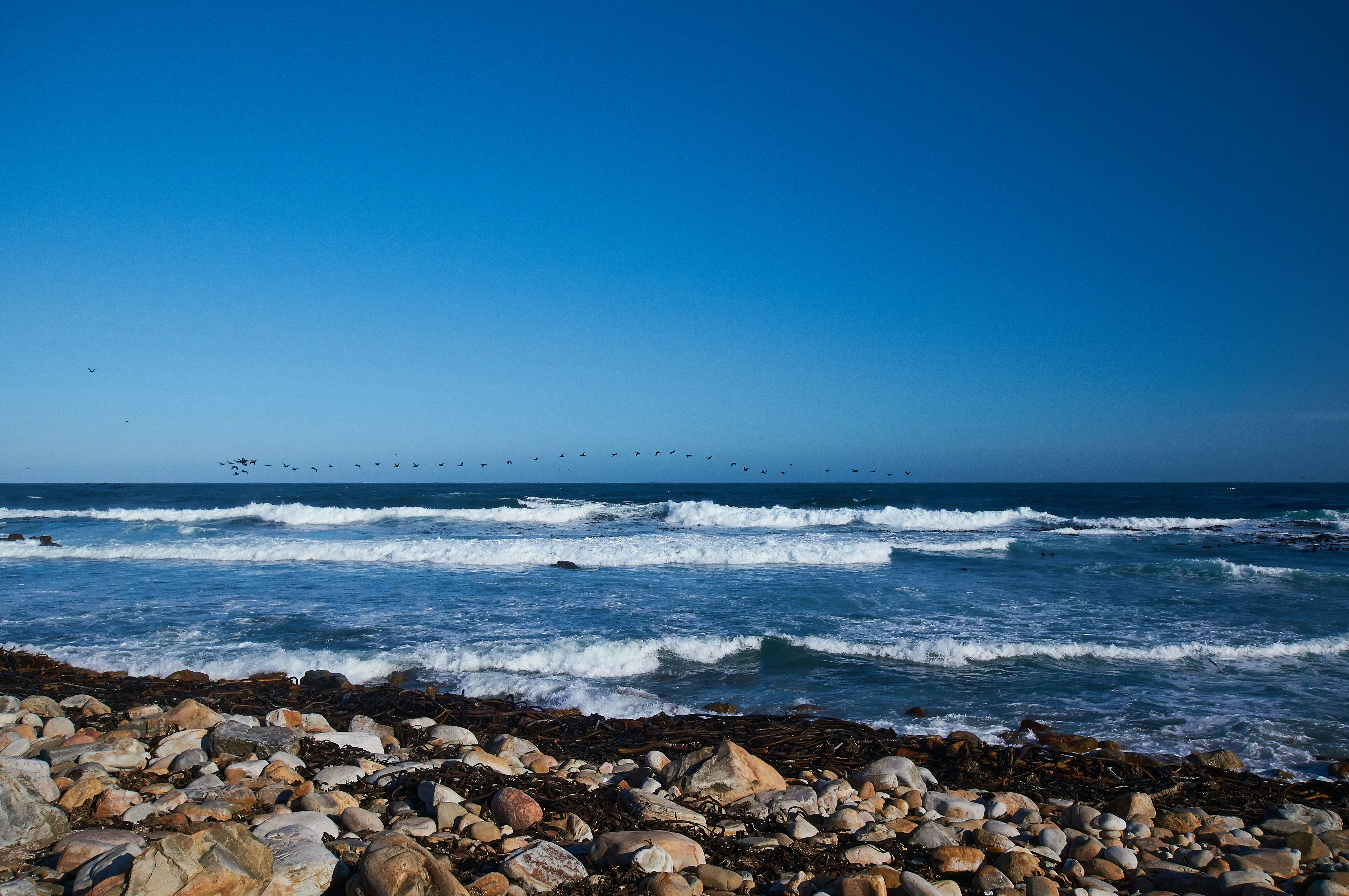 Foto zum Thema Ein felsiger Strand mit Wellen, die an Land kommen ...