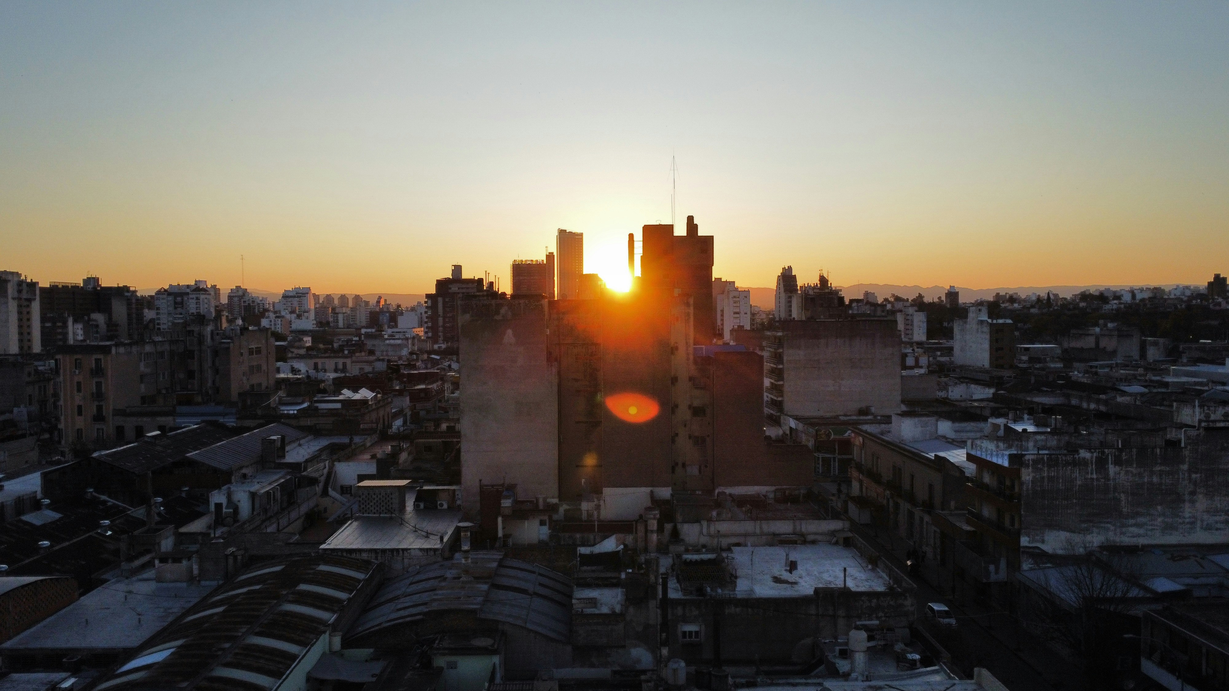 The sun is setting over a city with tall buildings photo – Free Sol ...