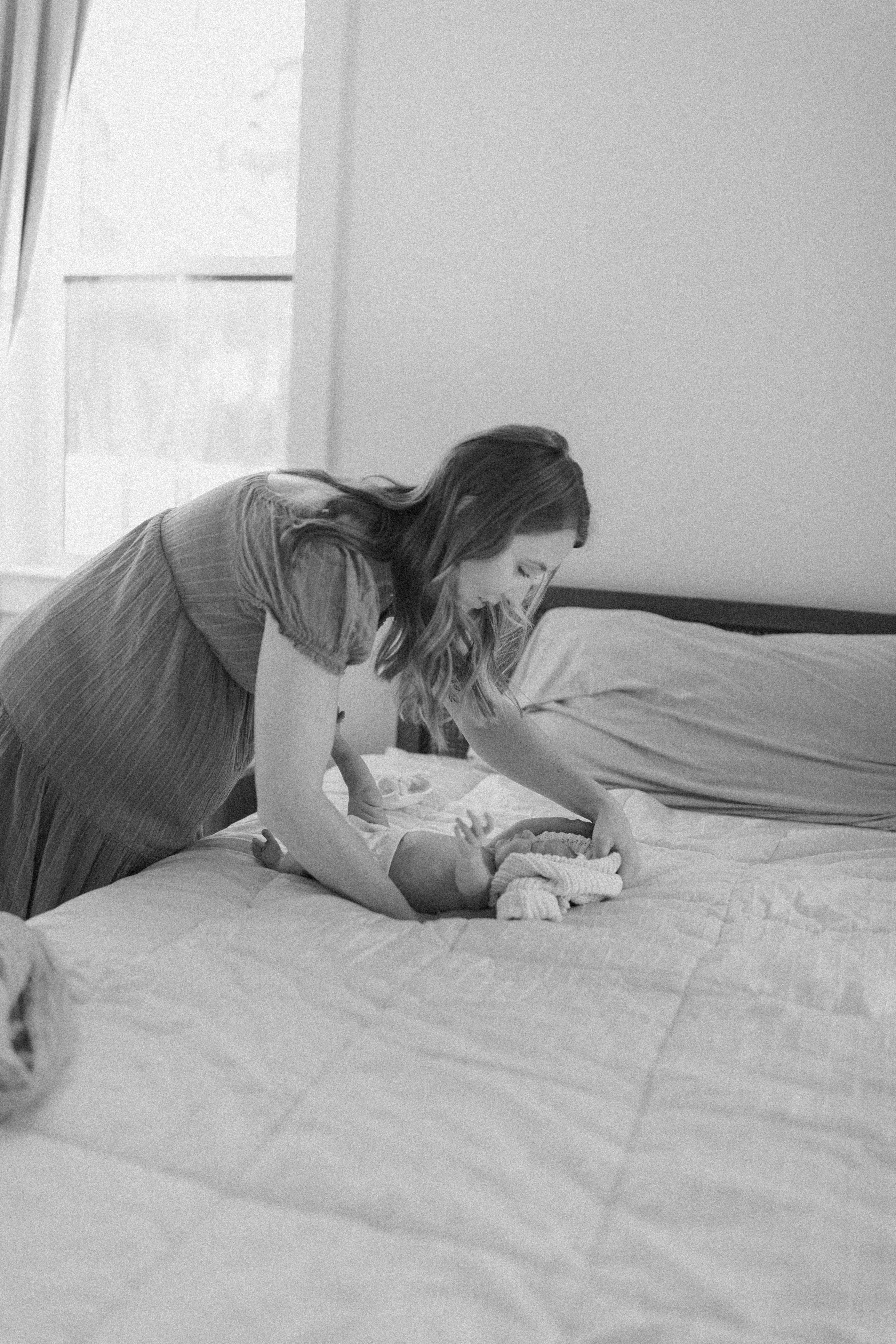 Une femme allongée sur un lit tenant un bébé photo – Photo Visage ...