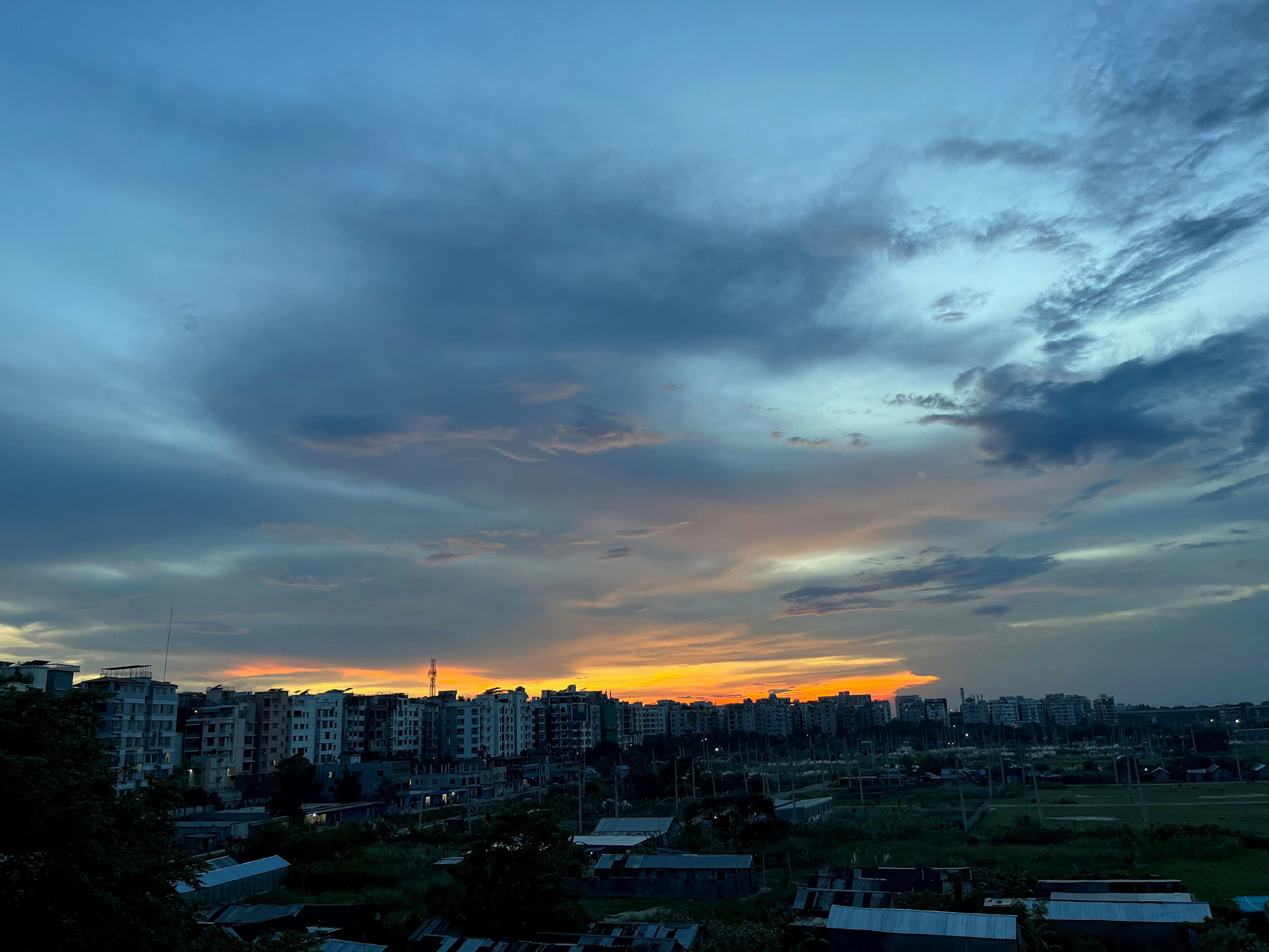 a view of a city at sunset from a hill