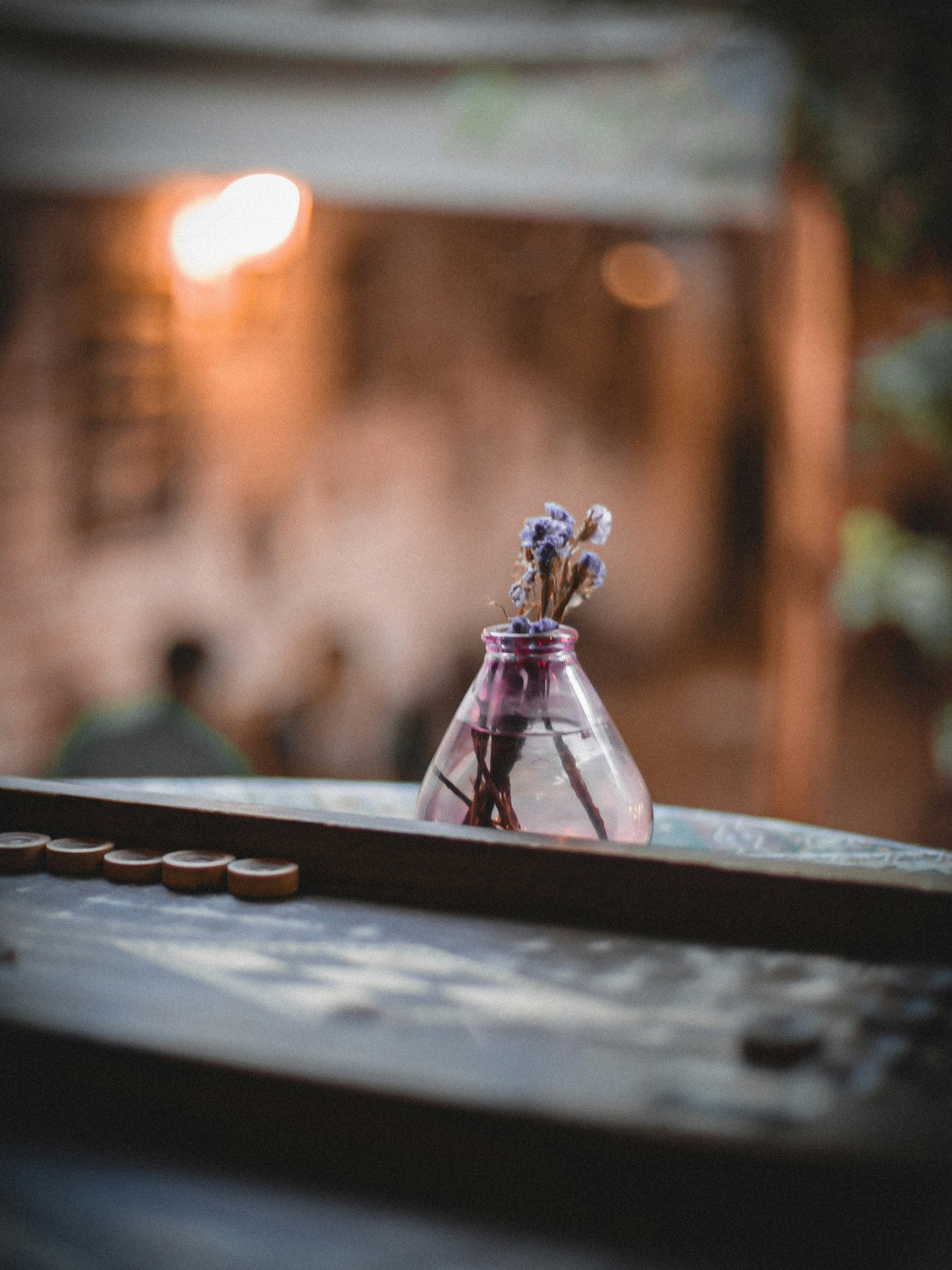 A glass vase filled with flowers sitting on top of a wooden table photo ...