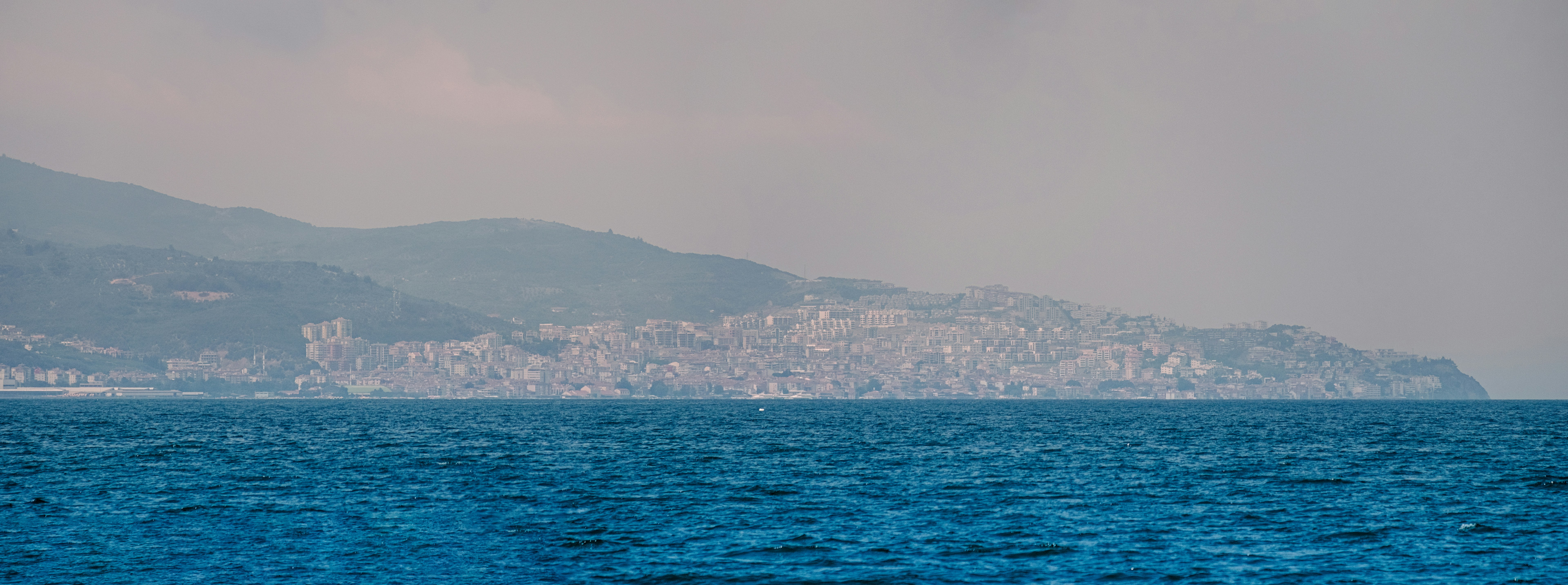 Horizon Sketch: Distant Coastline Looms Over Deep Blue Seas