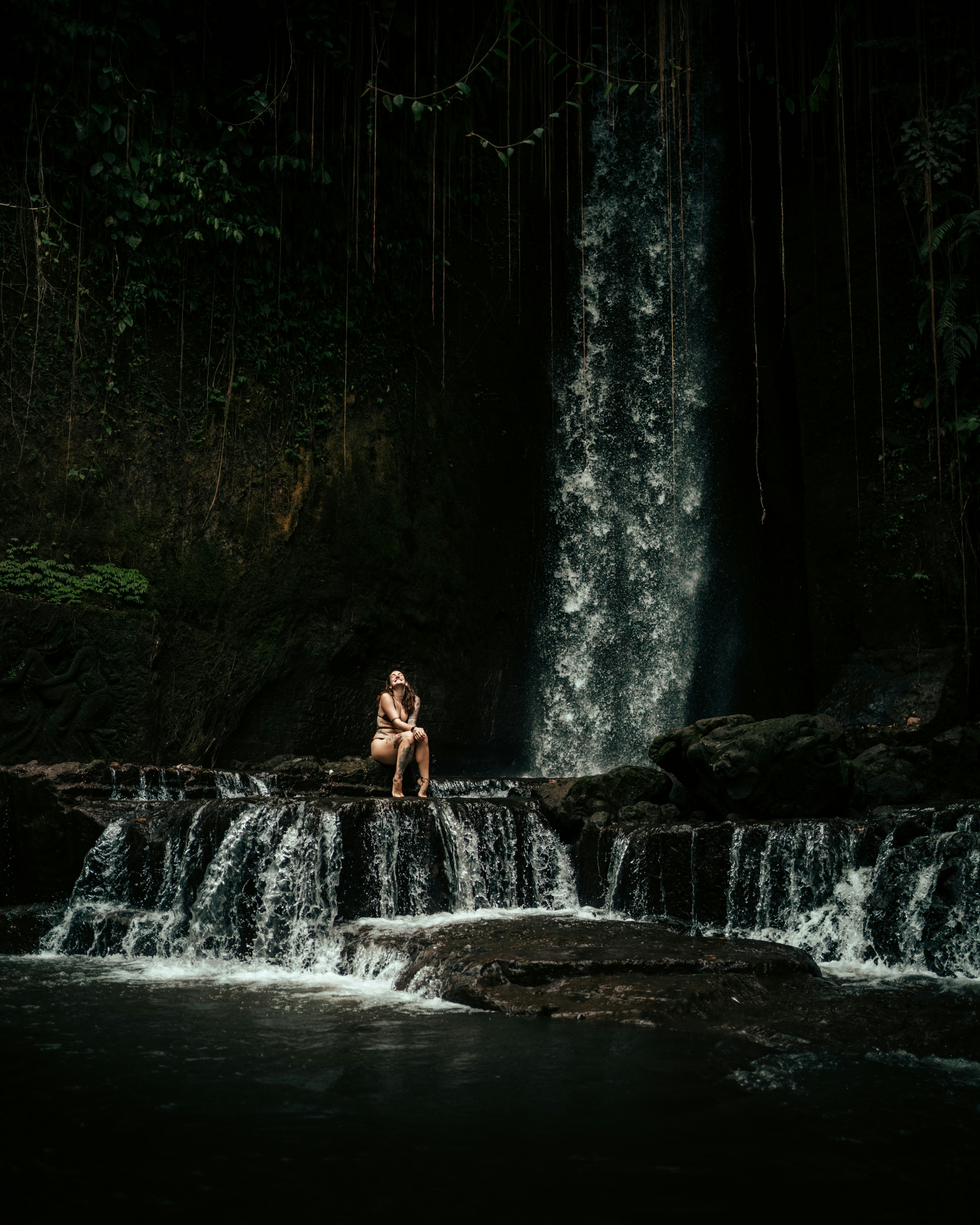 Une personne assise sur un rocher devant une cascade photo – Photo ...