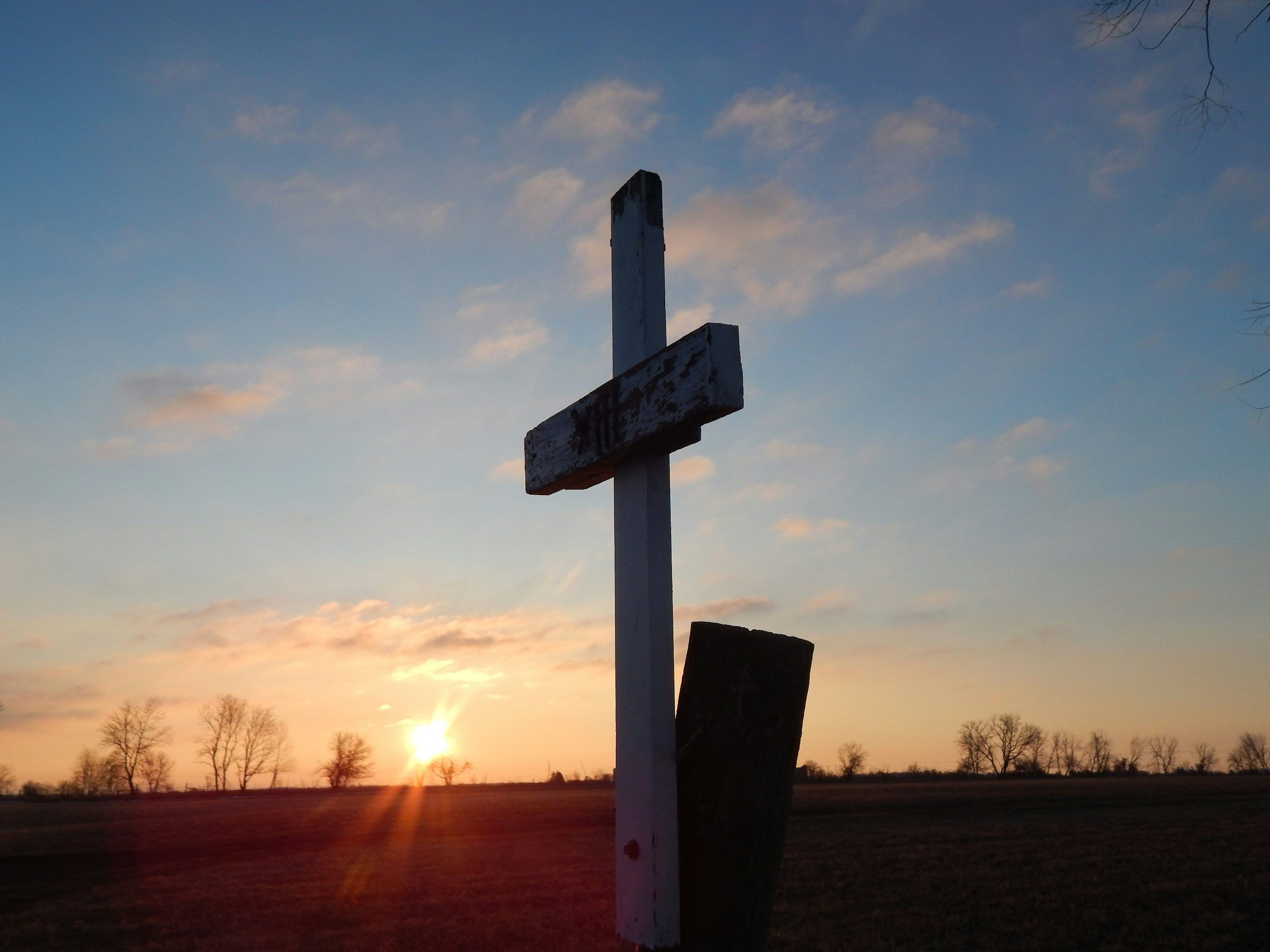 Une croix dans un champ avec le soleil couchant en arrière-plan photo ... Une croix dans un champ avec le soleil couchant en arrière-plan photo ...