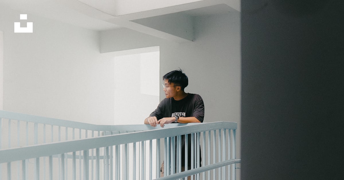 Un Homme Debout Sur Un Balcon à Côté Dune Balustrade Blanche Photo