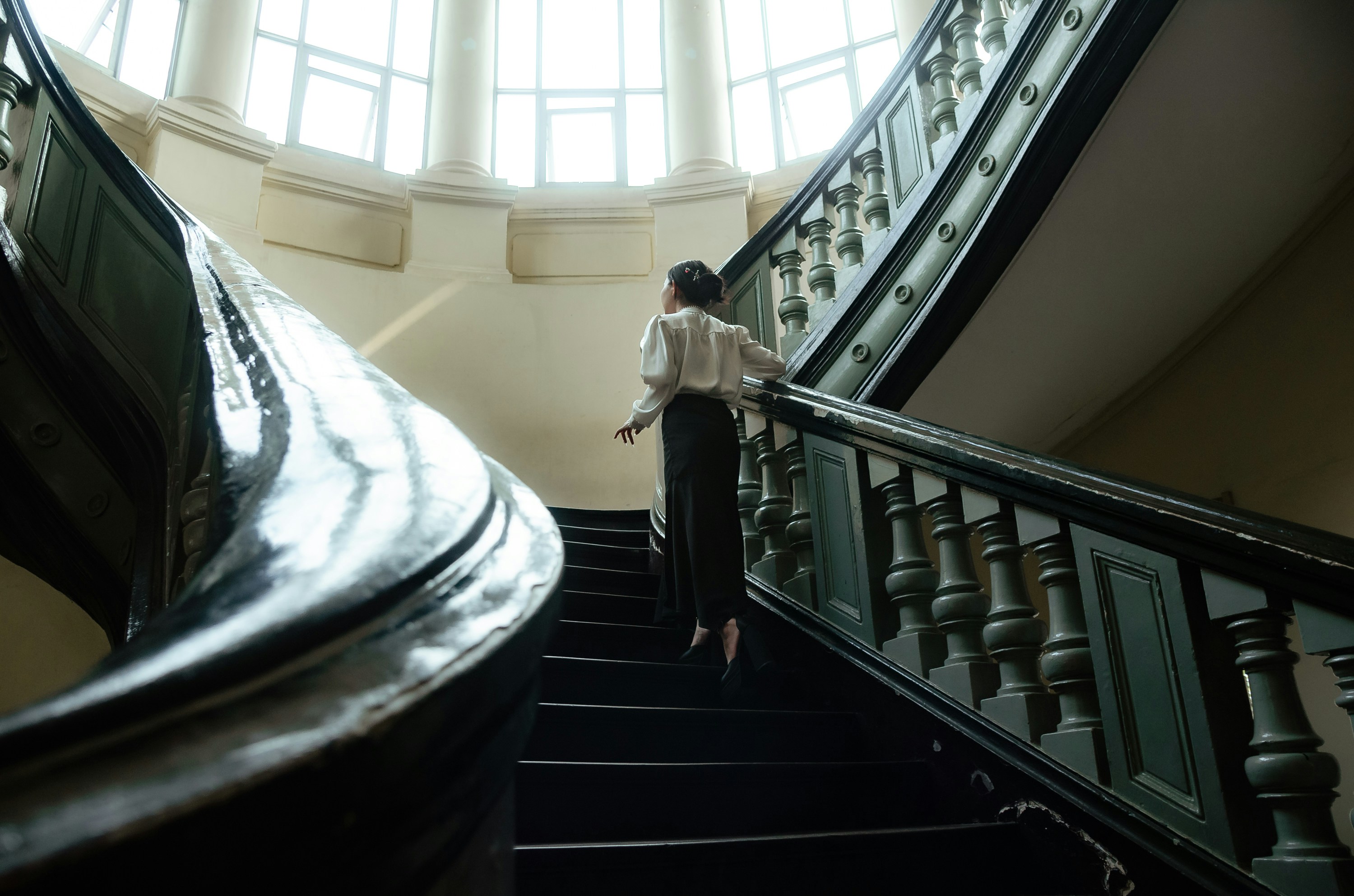 Quiet Ascent on the Spiral Staircase Beneath a Glass Atrium