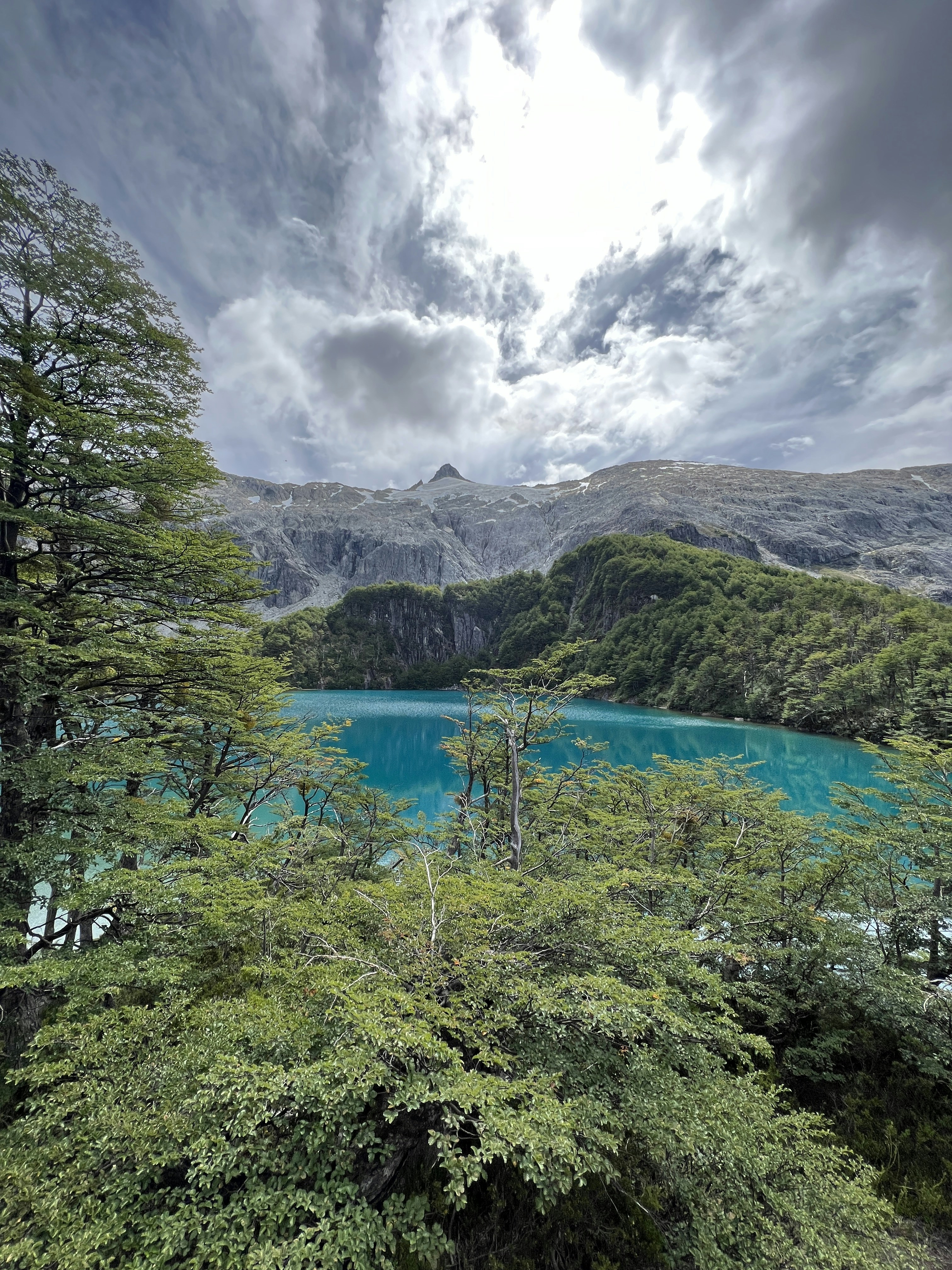 Emerald Crater: turquoise lake framed by alpine forest and jagged peaks