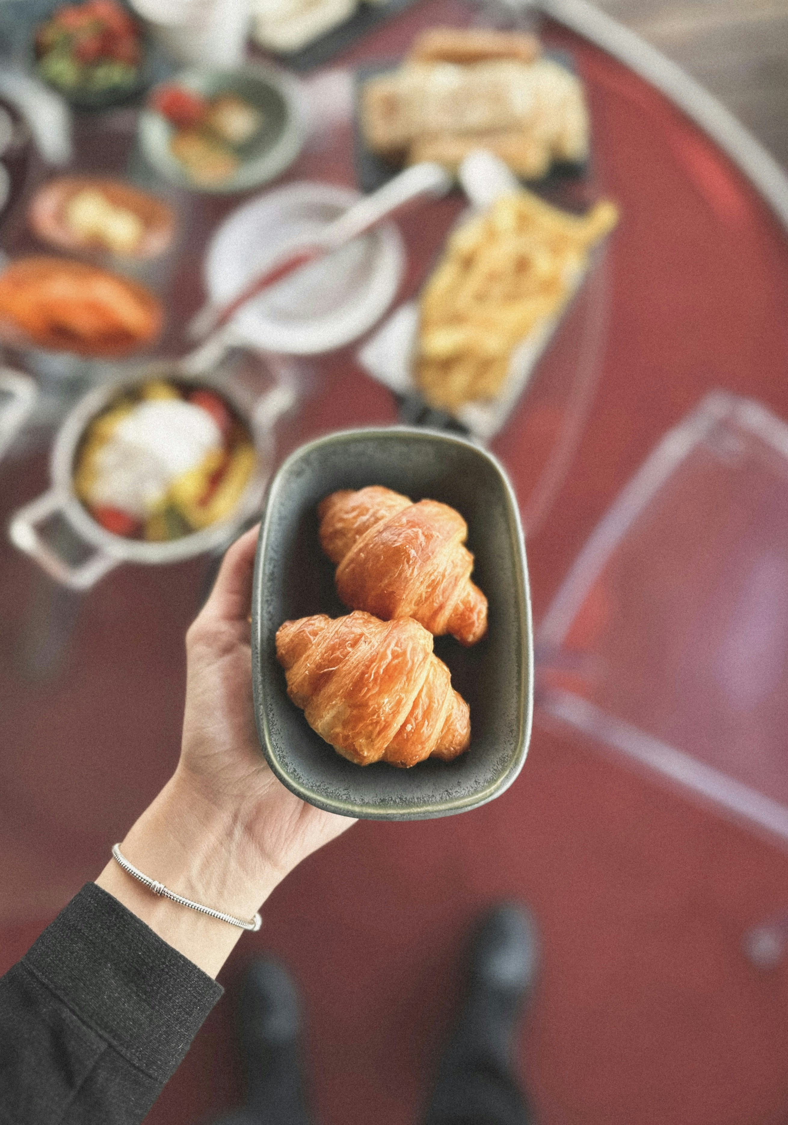 A person holding a bowl of food with croissants in it photo – Free ...