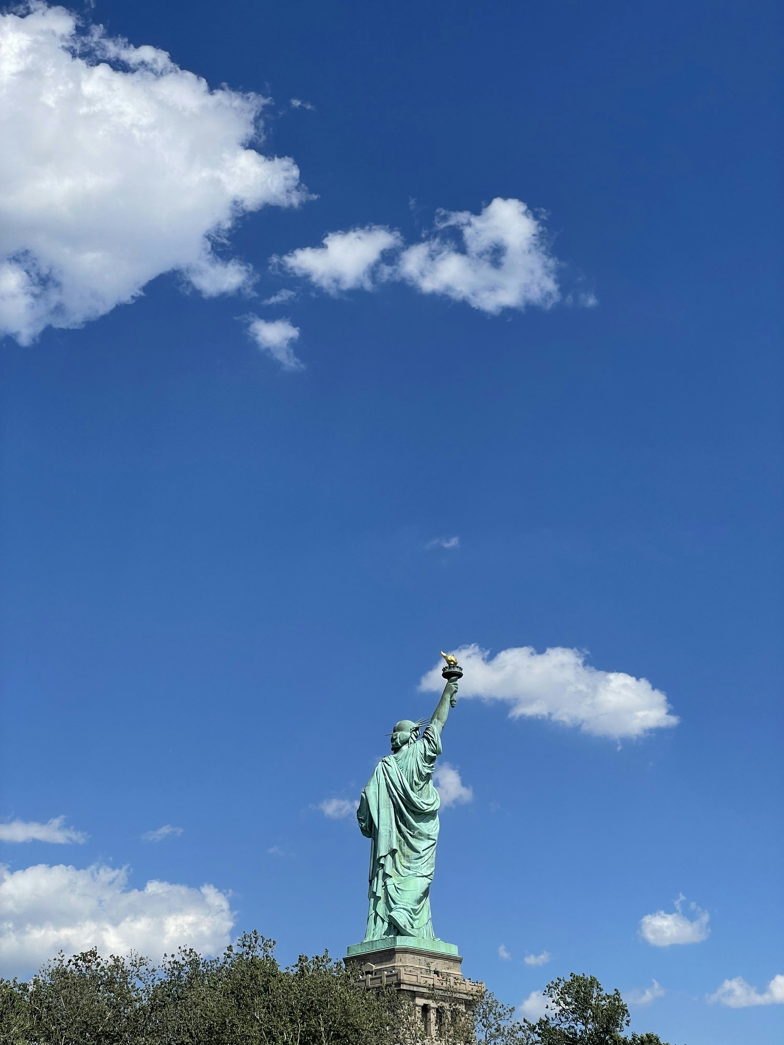 The statue of liberty is surrounded by trees photo – Free Art Image on ...
