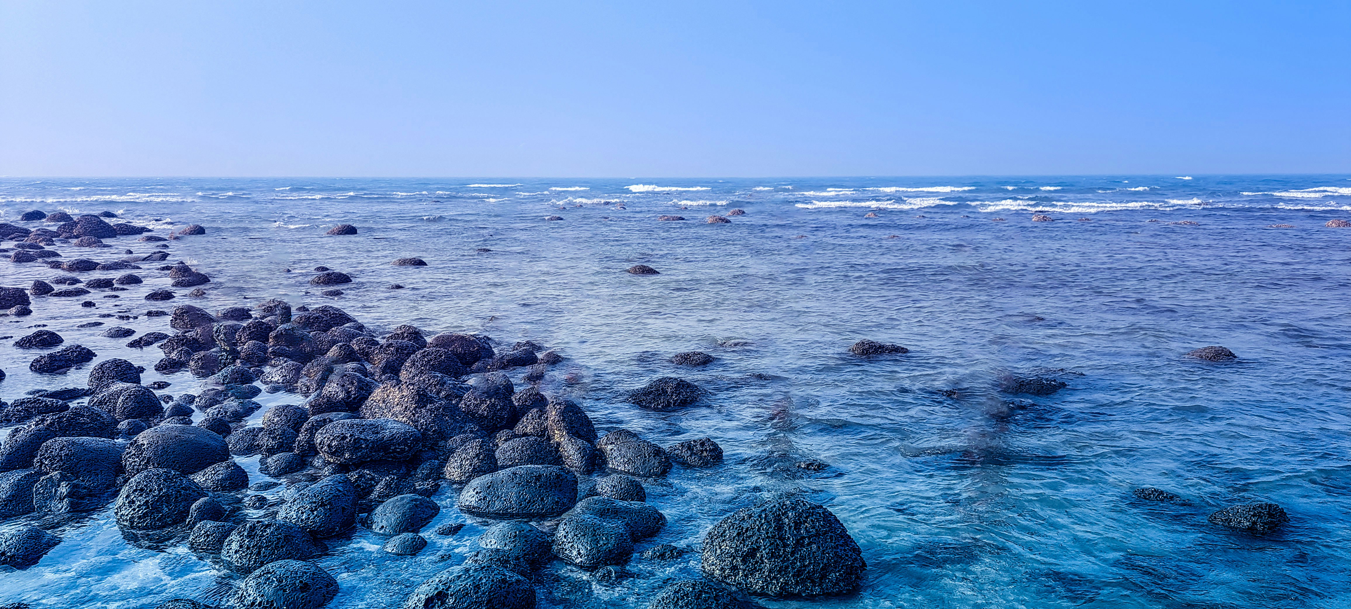 A rocky beach with blue water and rocks photo – Free Saint martin Image ...