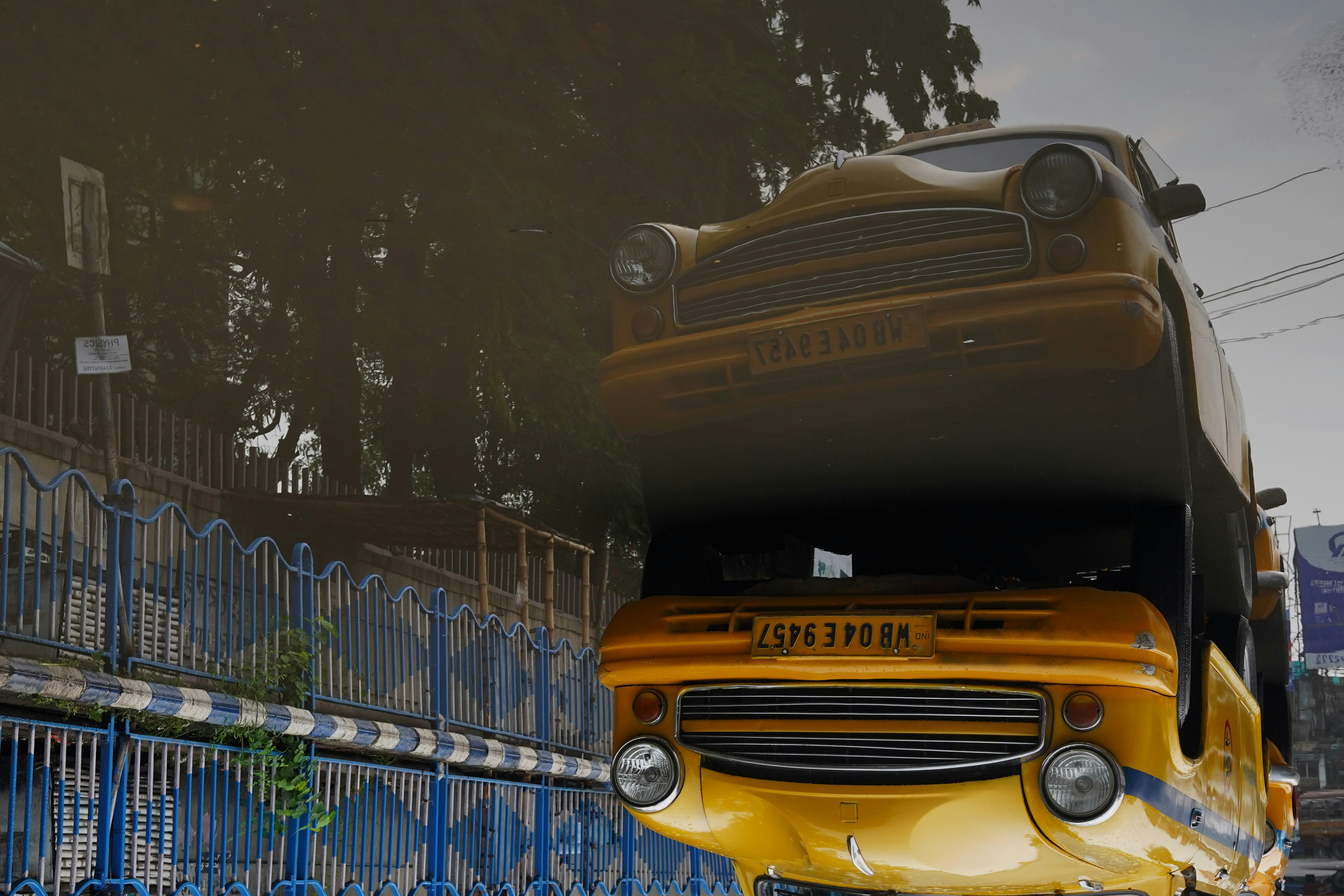 Precarious Stack of Yellow Buses in a Narrow Urban Alley