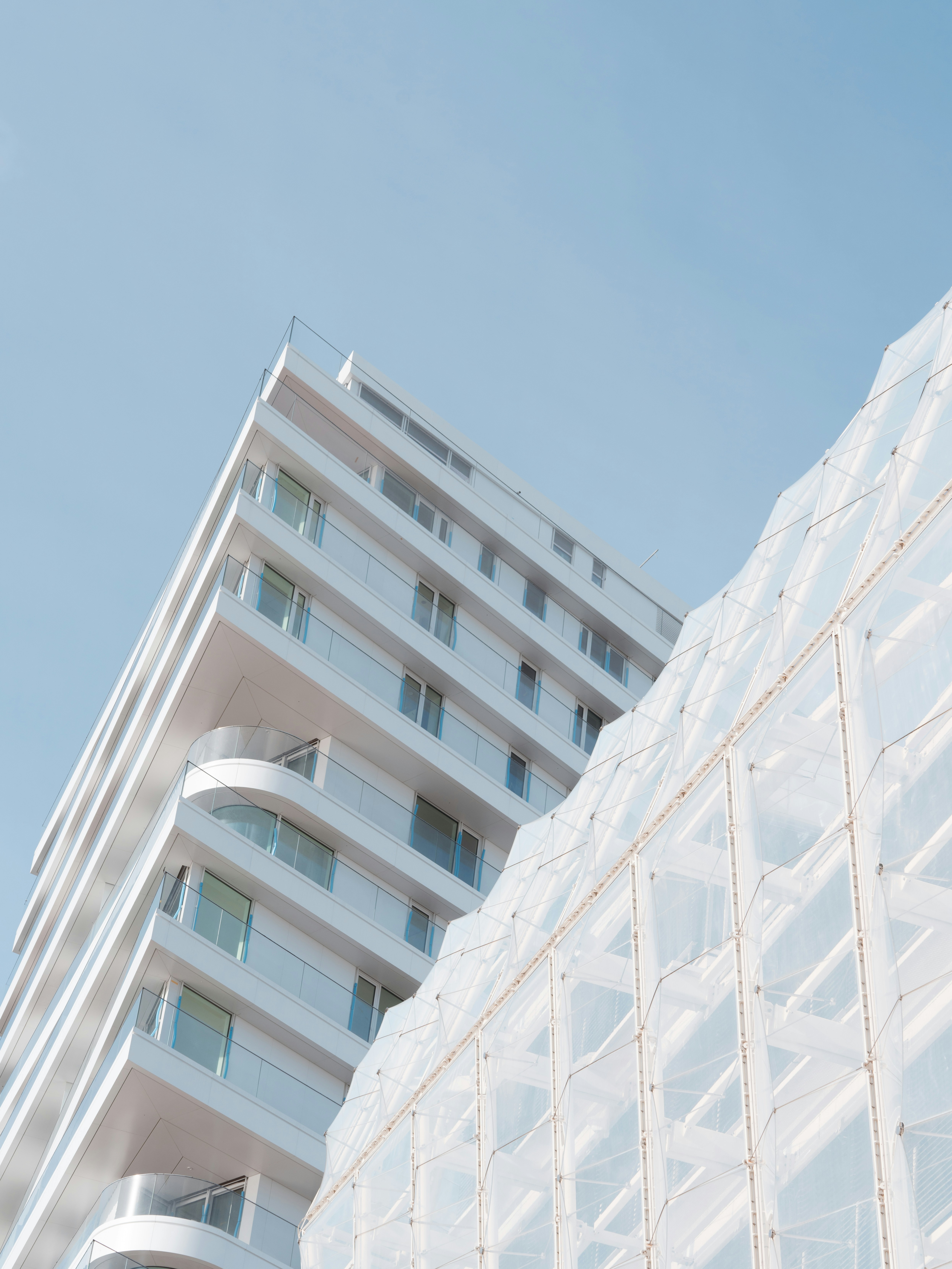 A tall white building next to a tall white building photo – Free ...