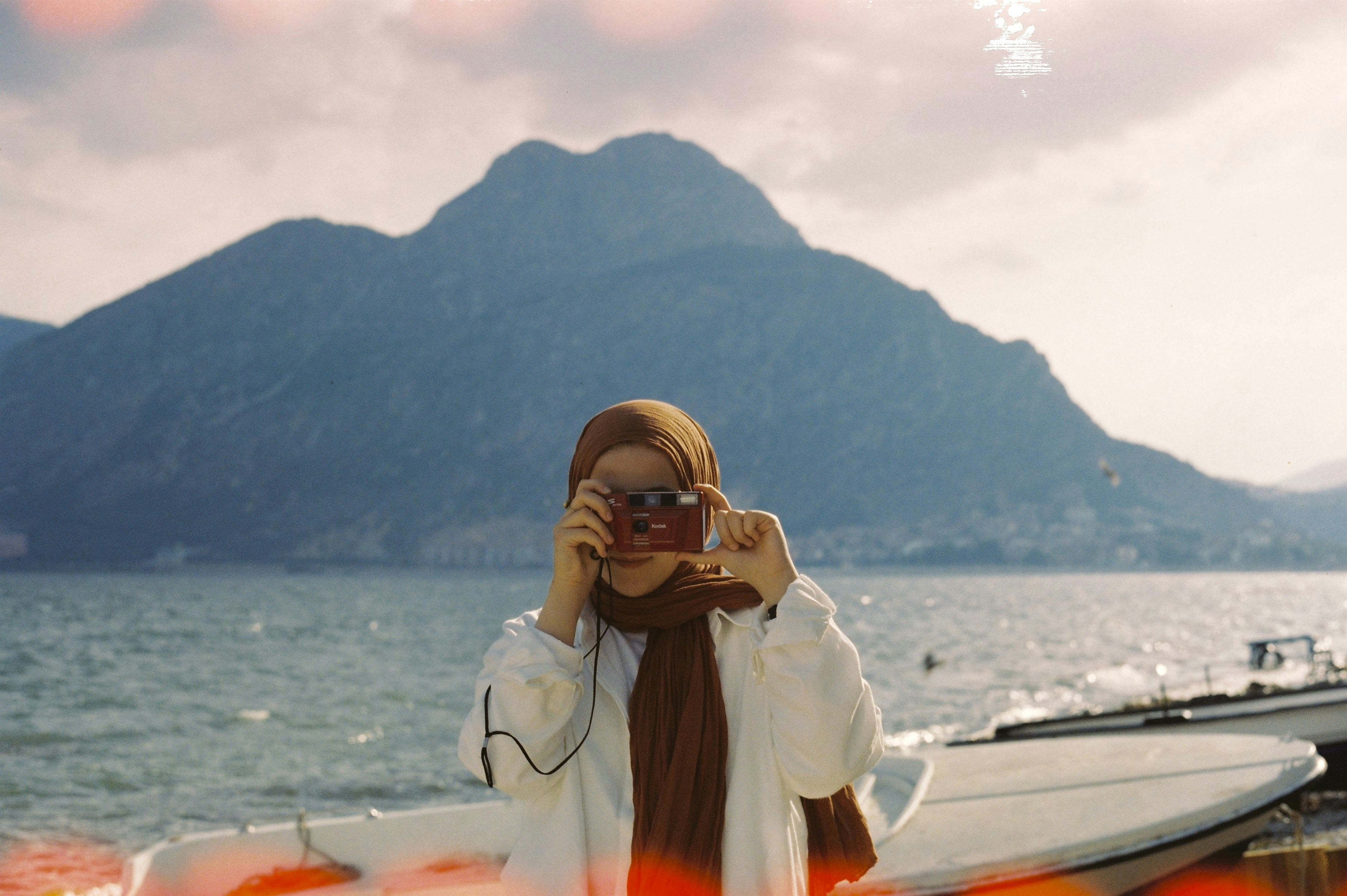a woman taking a picture of a boat on the water