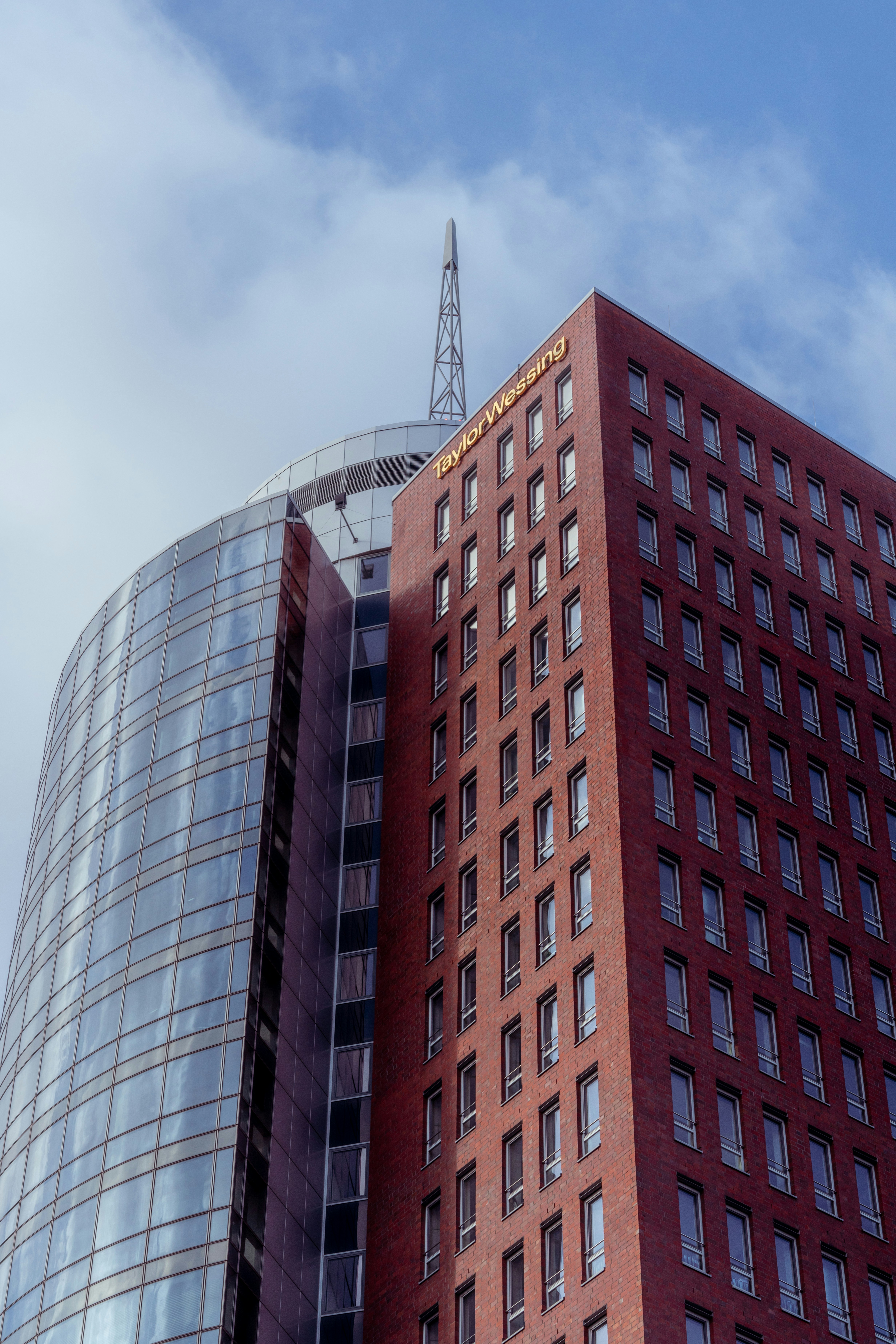 A tall red brick building with a radio tower in the background photo ...
