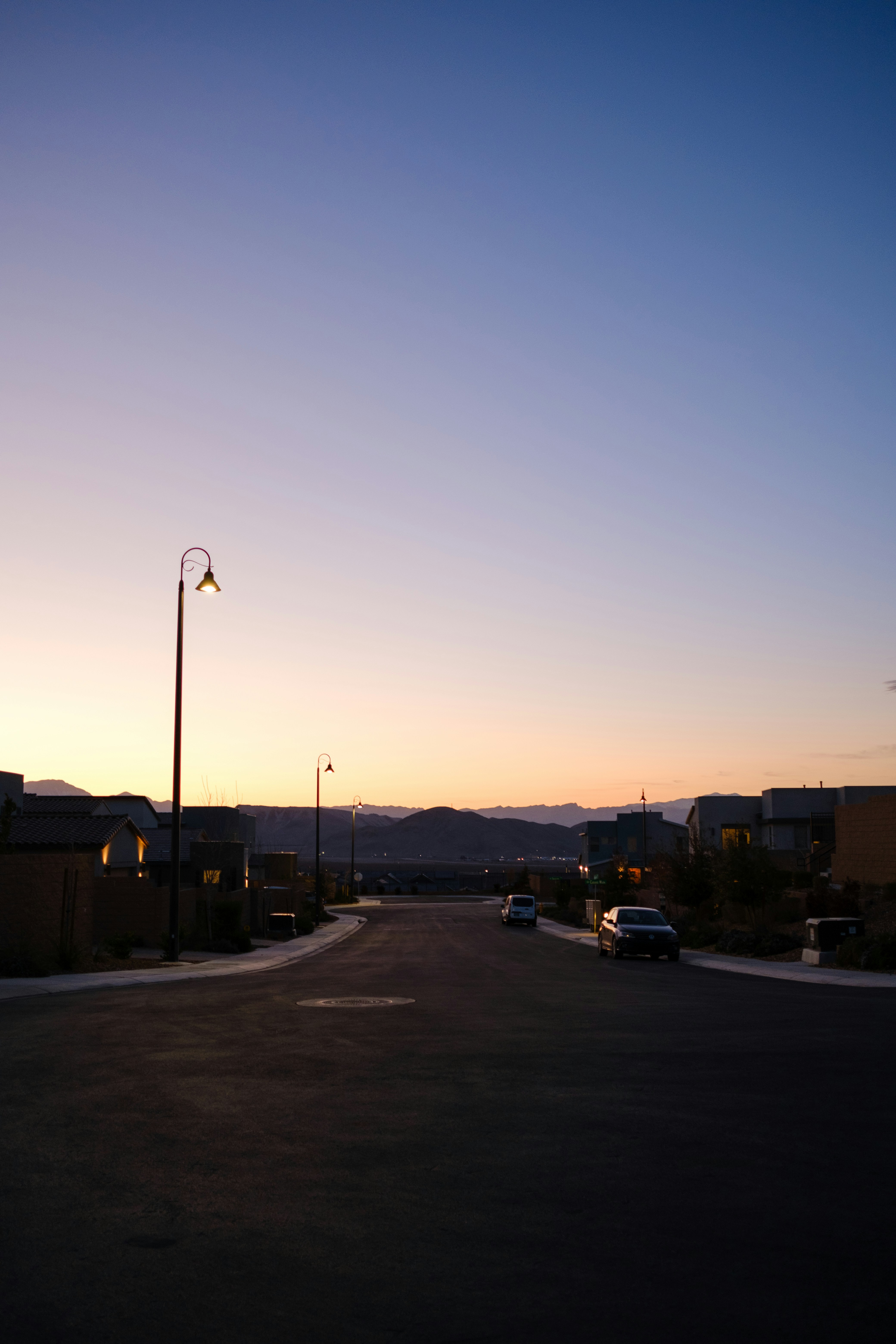 Twilight Lane: Suburban Lamps Toward the Distant Hills