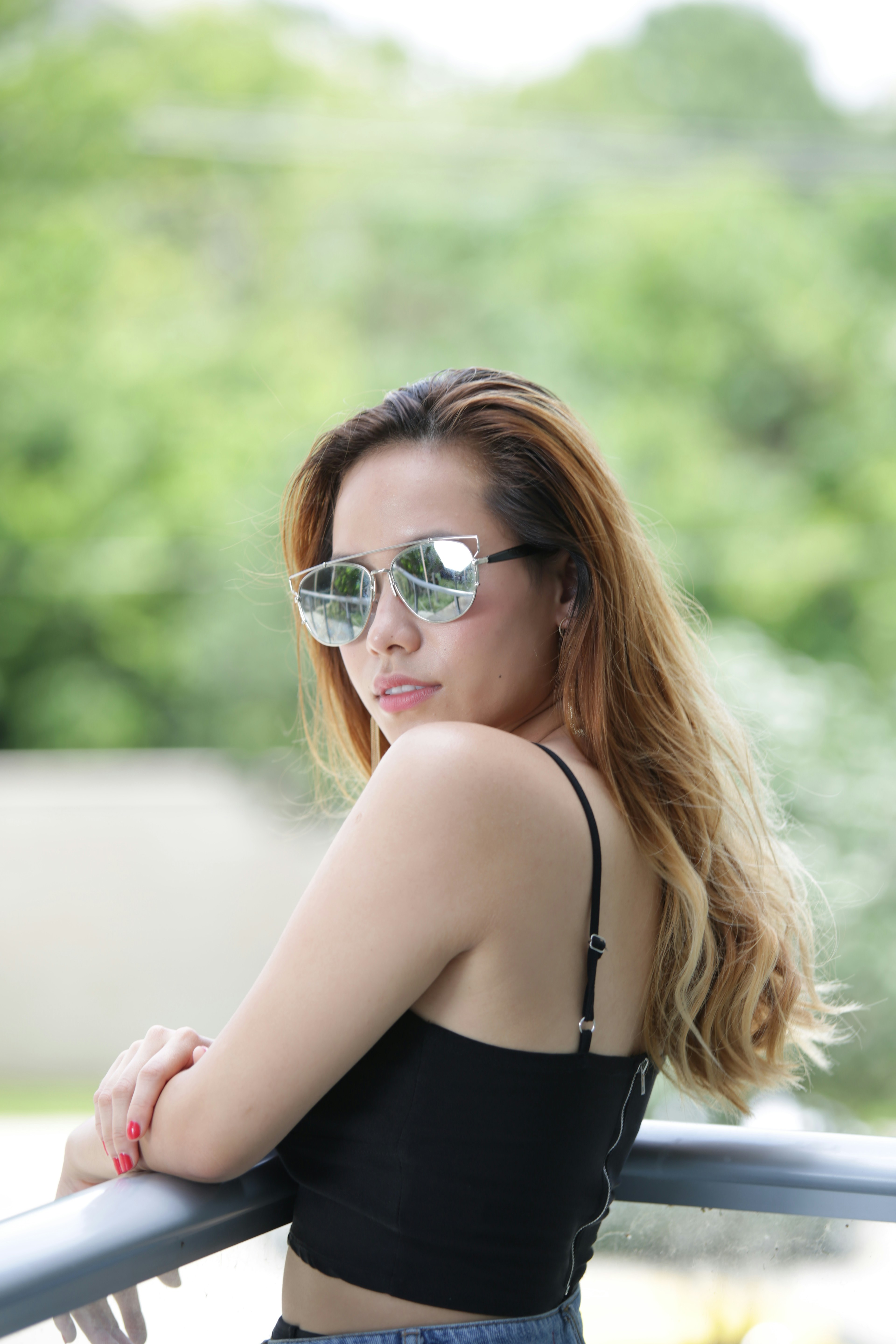 Una mujer con gafas de sol apoyada en una barandilla foto – Imagen de ...