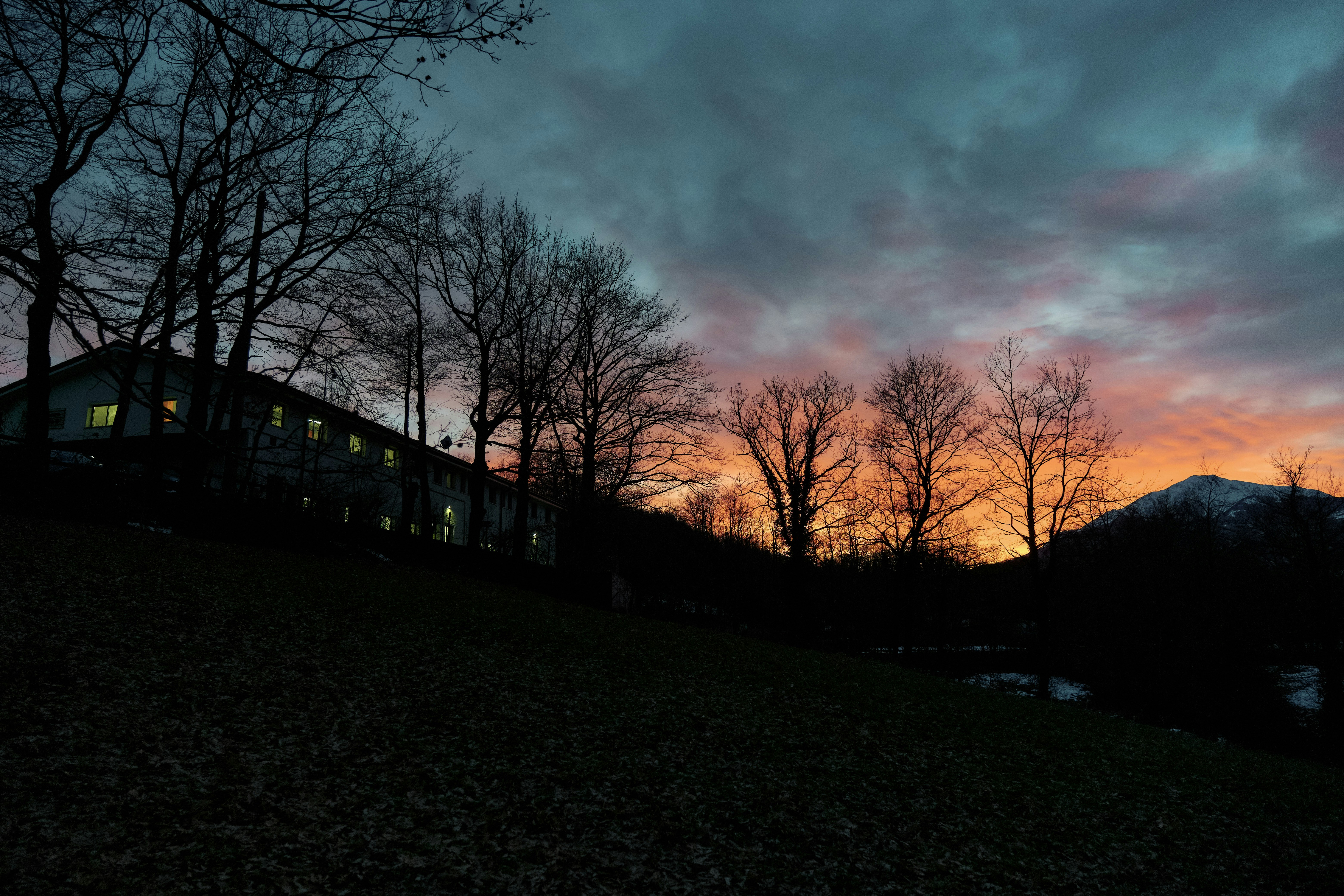Une maison assise au sommet d’une colline sous un ciel nuageux photo ...