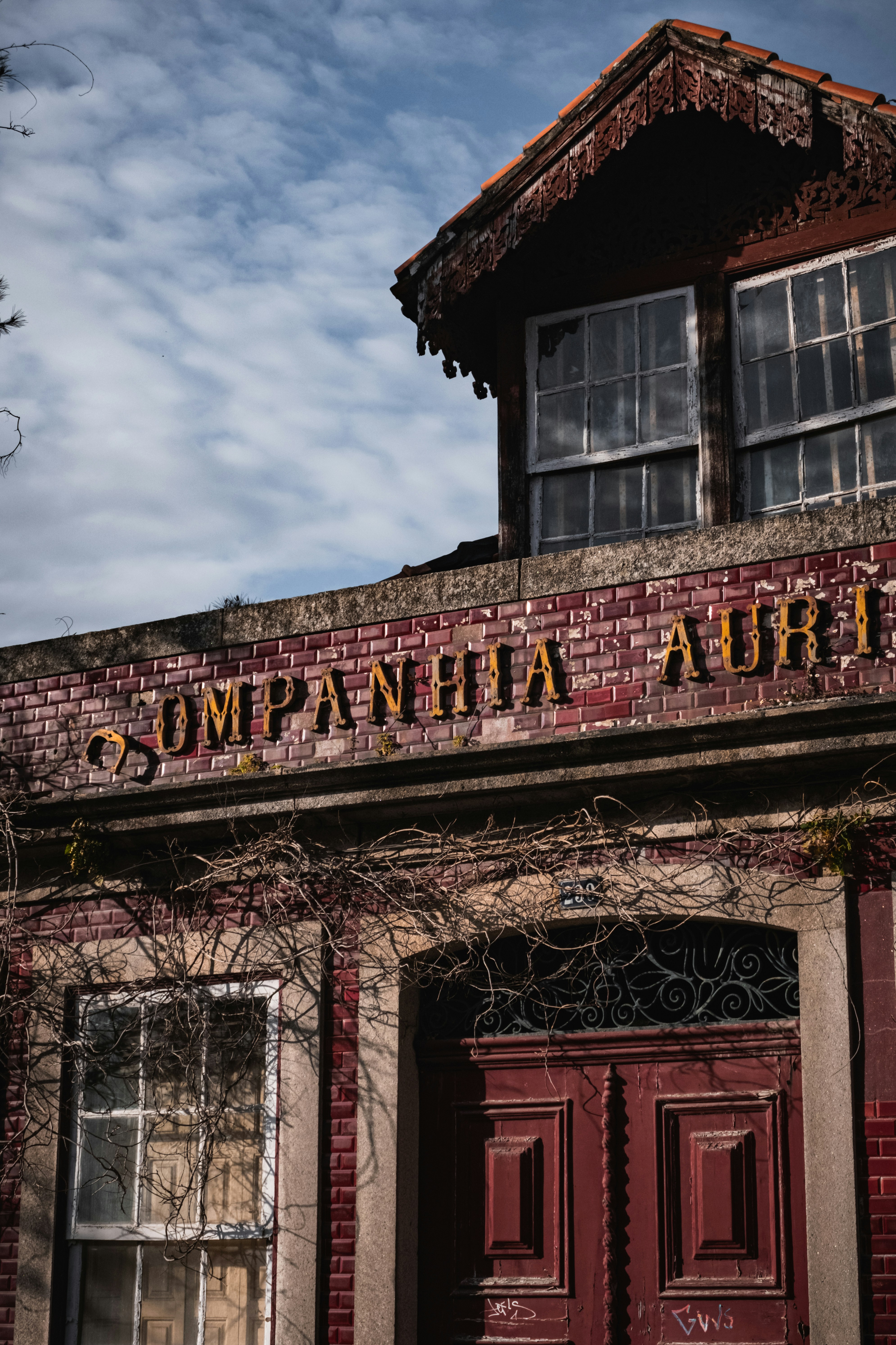 Red Door at the Edge of Decay: An Abandoned Companhia Facade