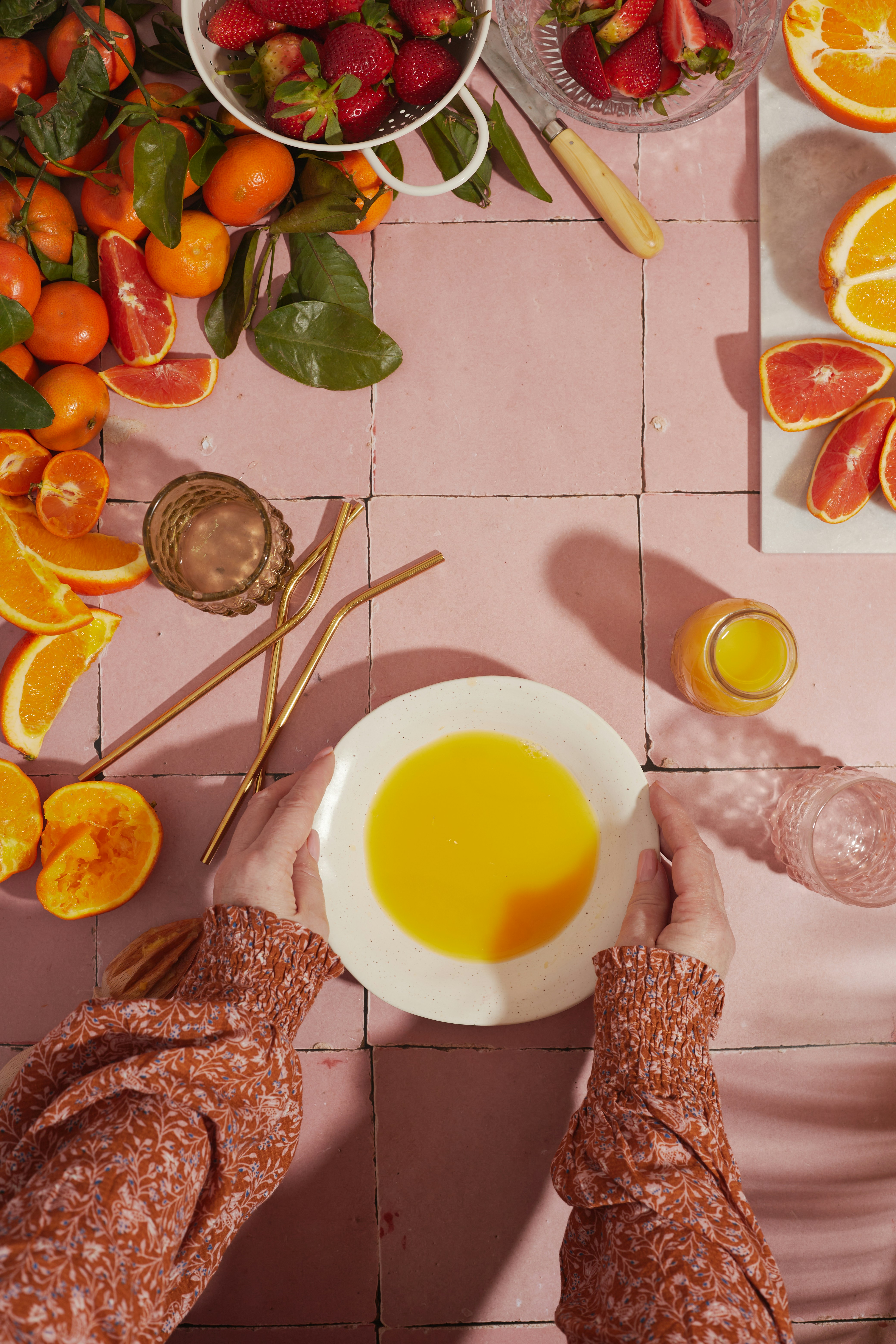 Pastel Tile Breakfast: Centered Egg Yolk Bowl Amid Citrus and Fruit