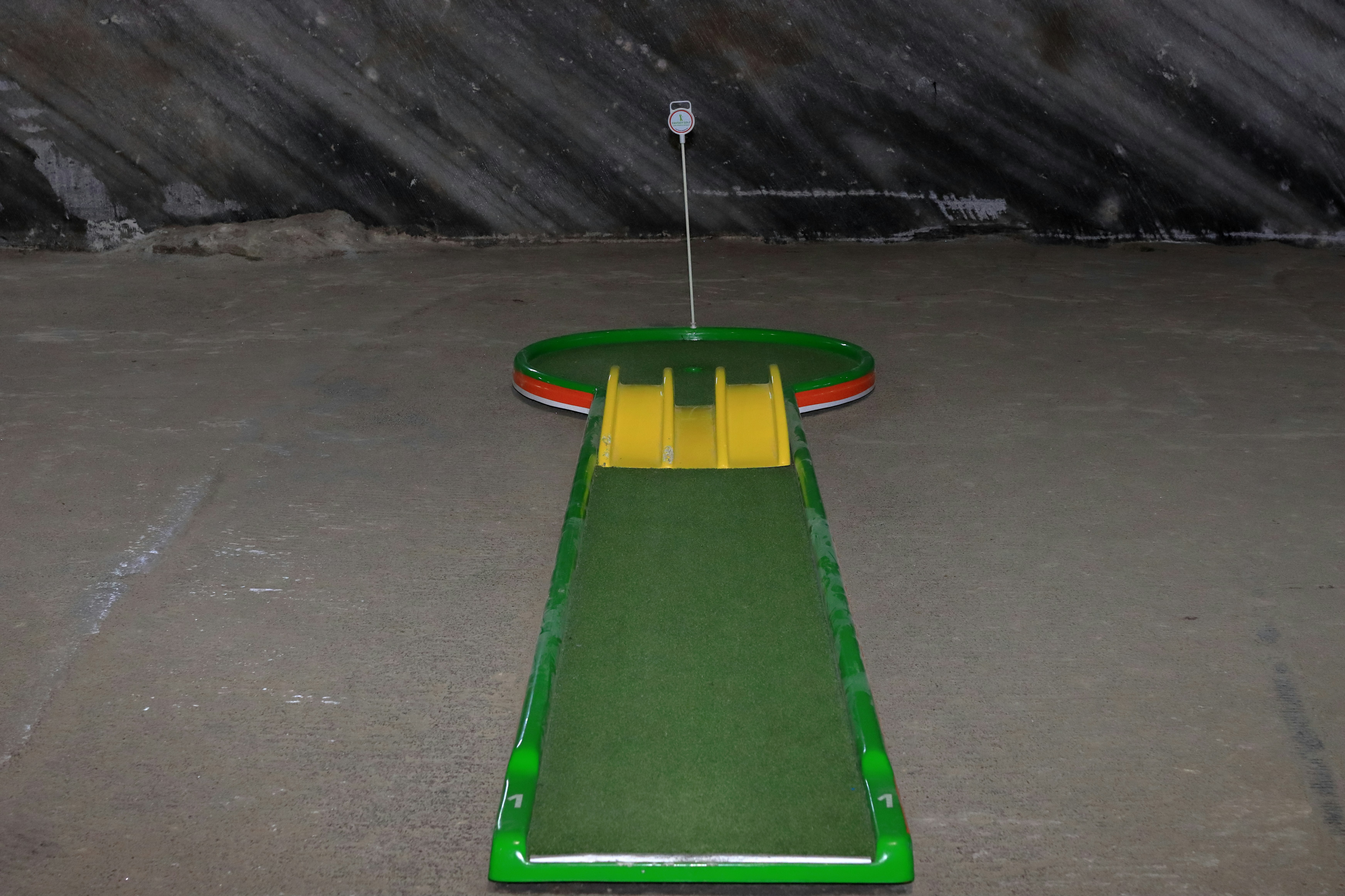 A green and yellow miniature golf course in a parking lot photo – Free ...