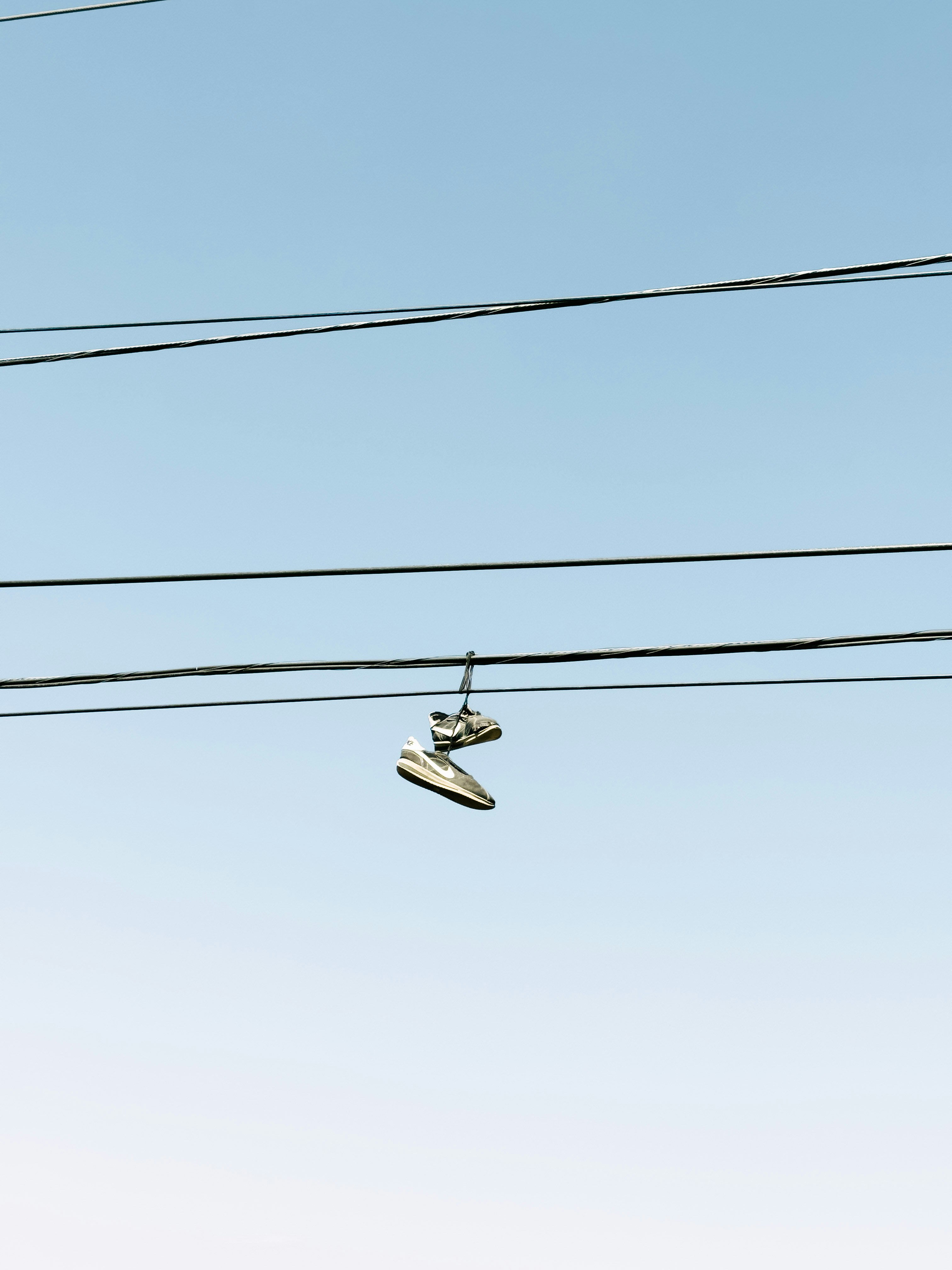 a pair of shoes hanging from a power lineBRUNO CERVERA