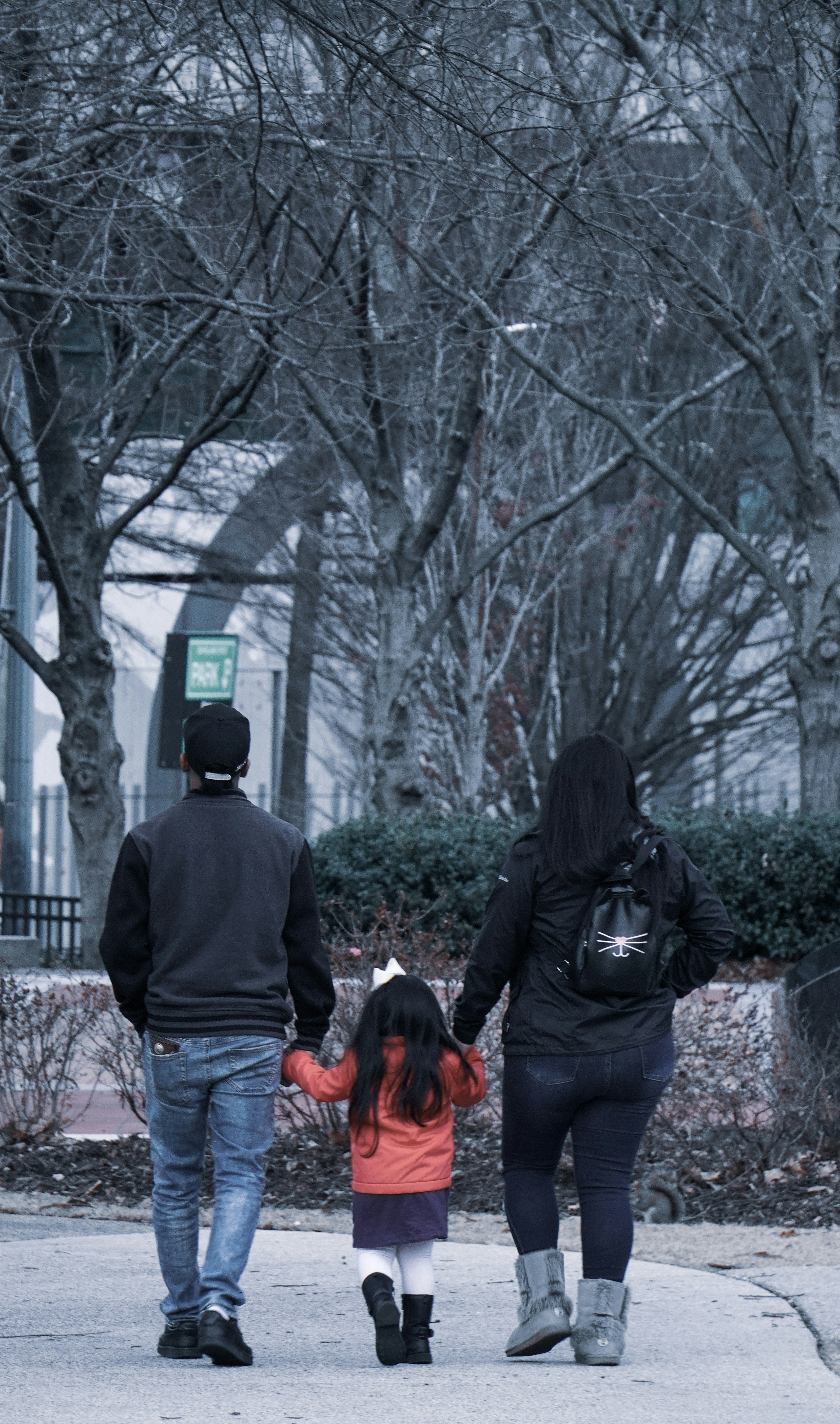 a man and a little girl walking down a sidewalk