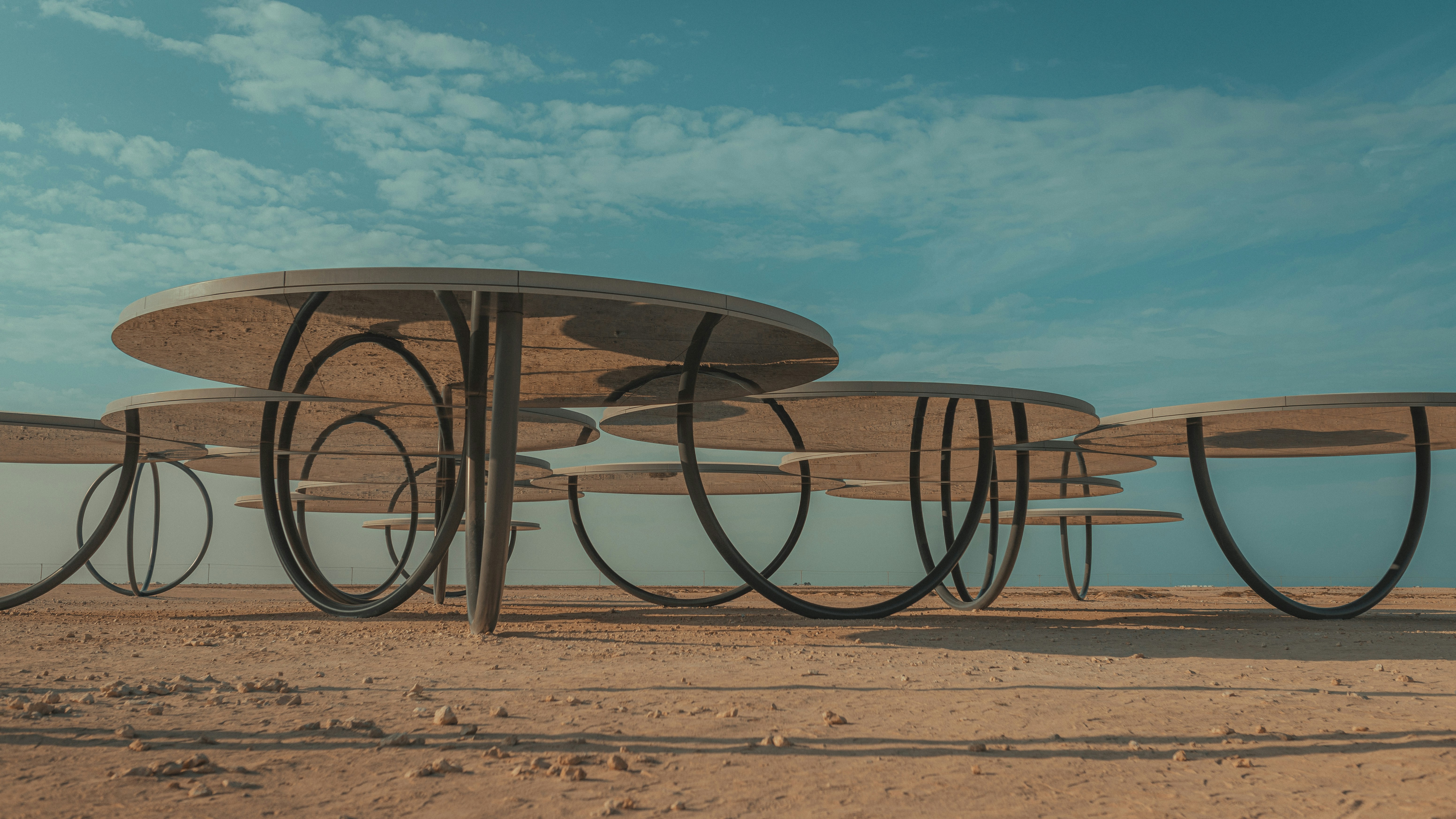 a group of tables sitting on top of a sandy beach