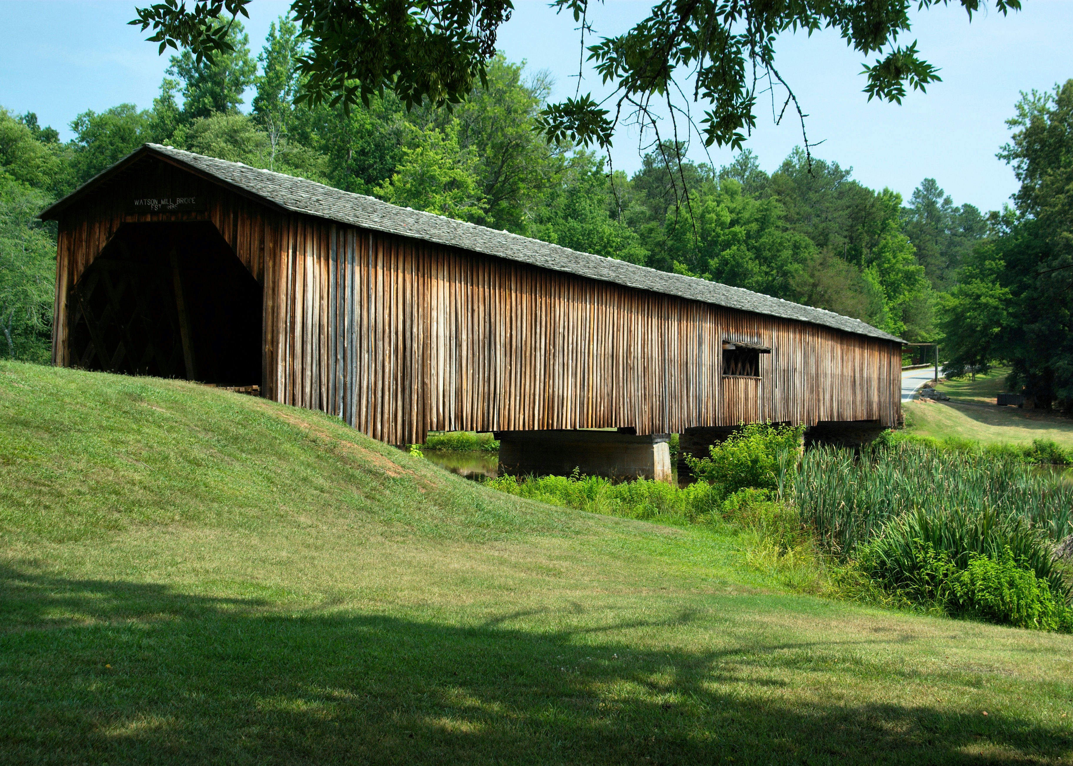 A large wooden covered bridge over a river photo – Free Covered bridge ...