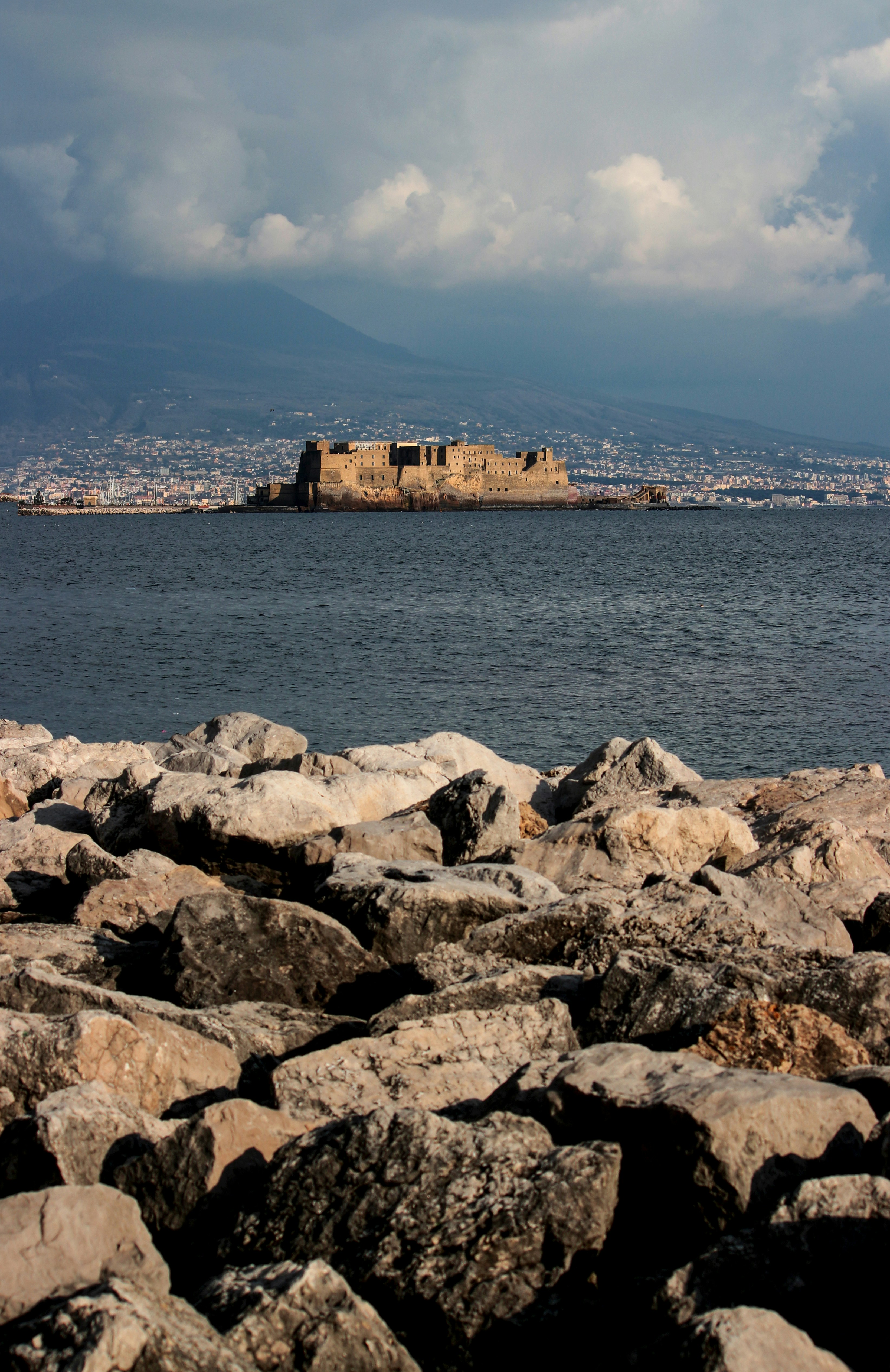 A large body of water surrounded by rocks photo – Free Metropolitan ...