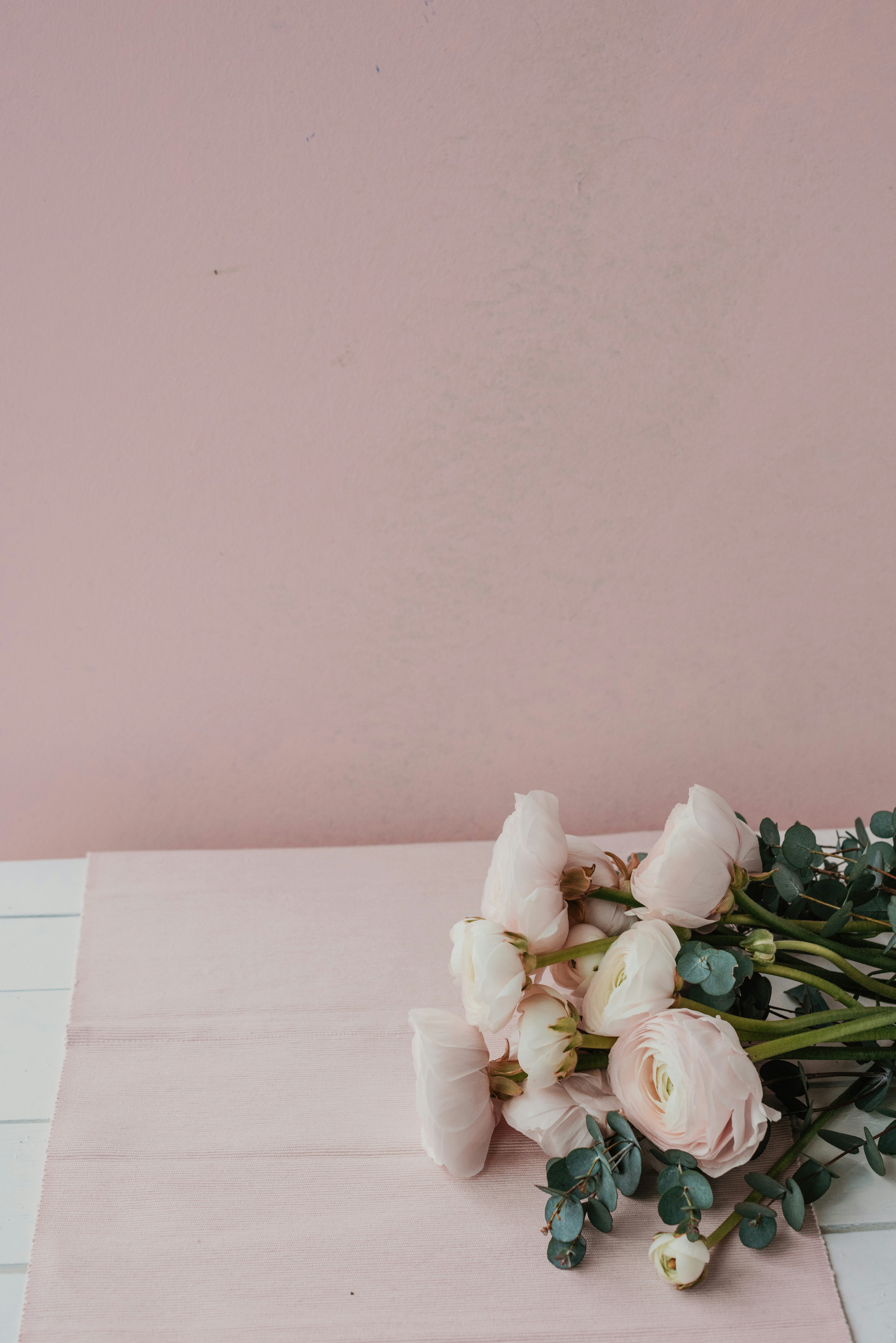 Foto Un ramo de flores sentado encima de una mesa rosa – Imagen Flor ...