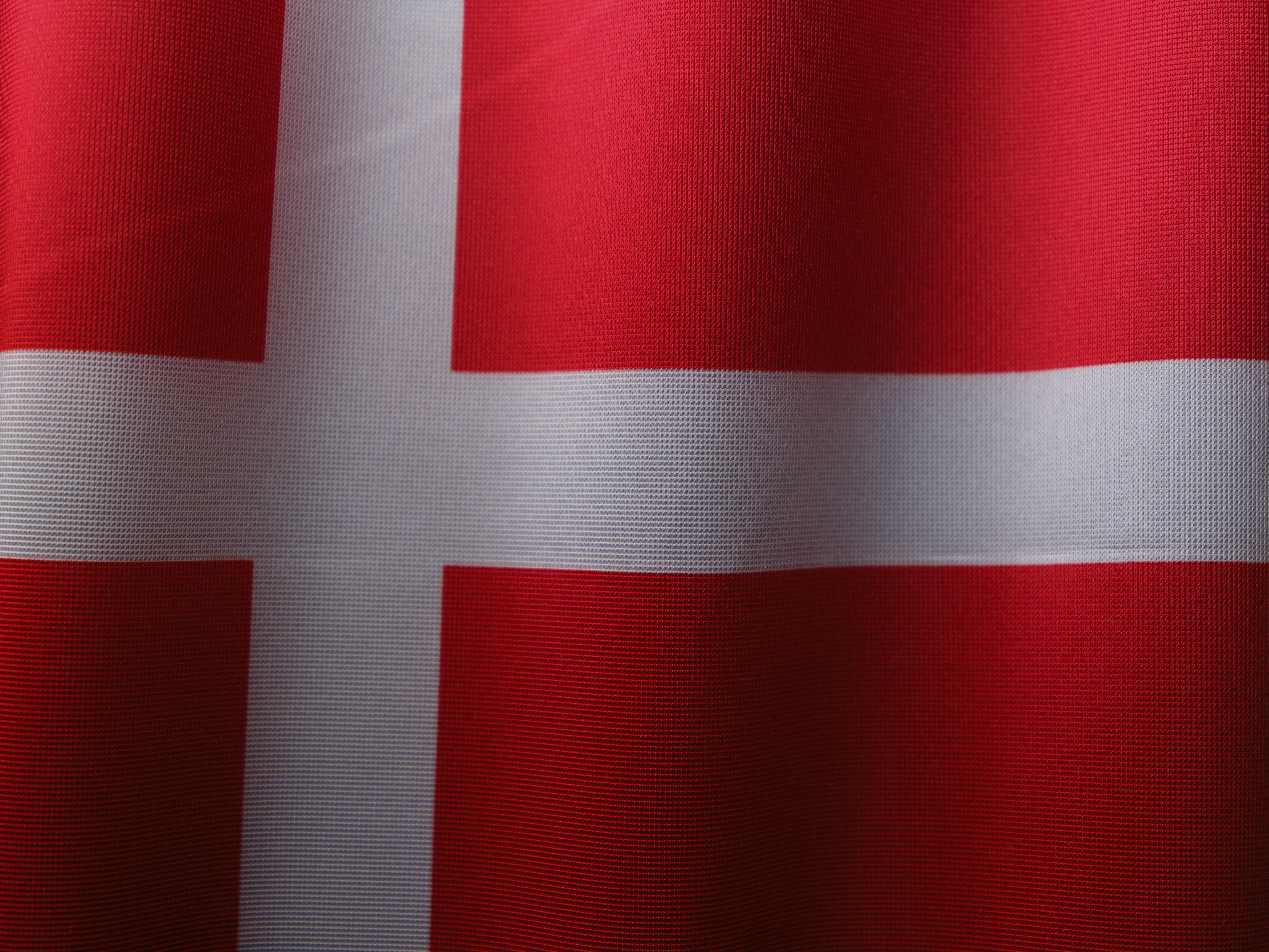 Close-up of the Danish flag, showcasing its bold red and white colors with a prominent cross design.