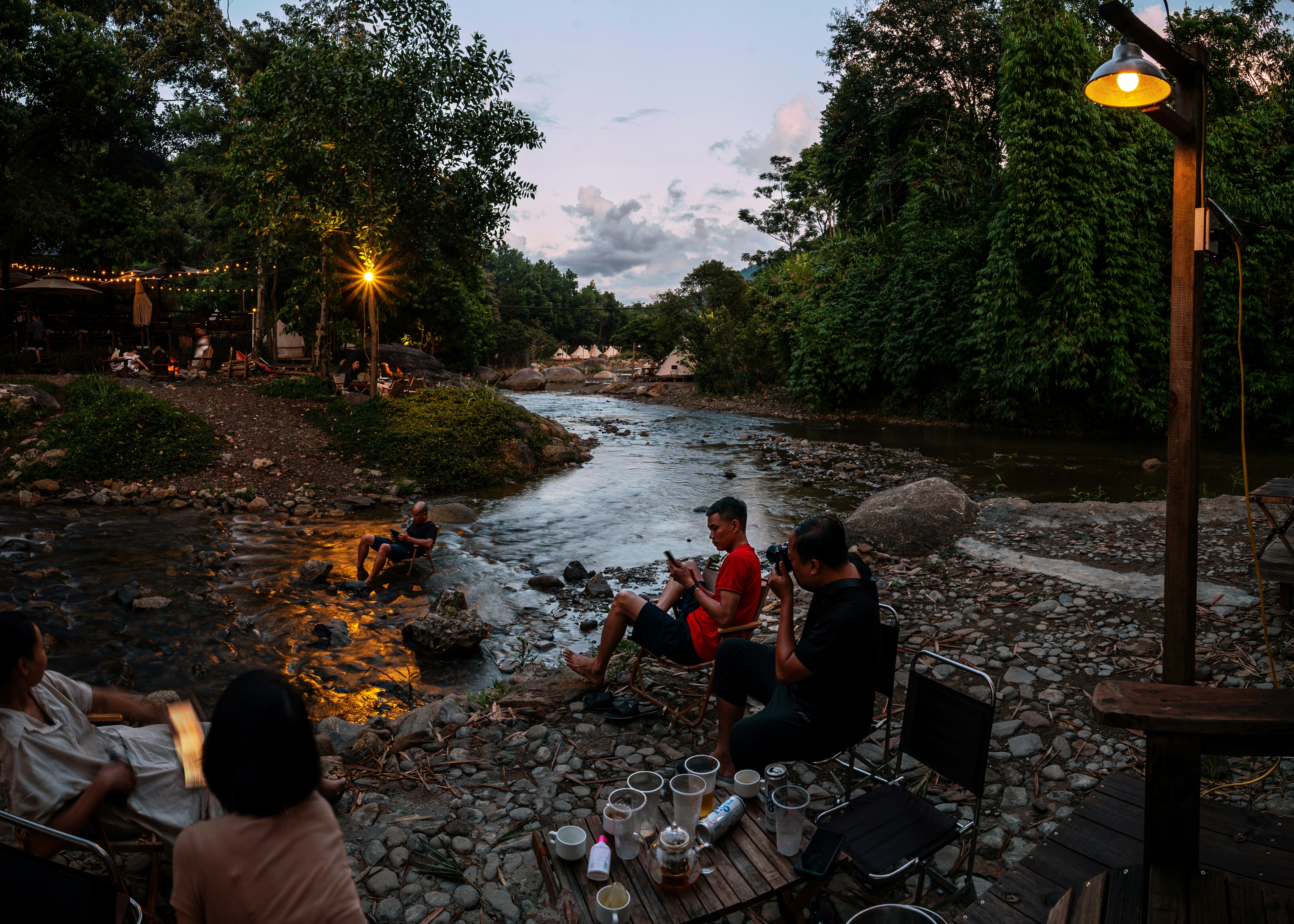Twilight on the Pebble Riverbank: a lantern-lit riverside gathering