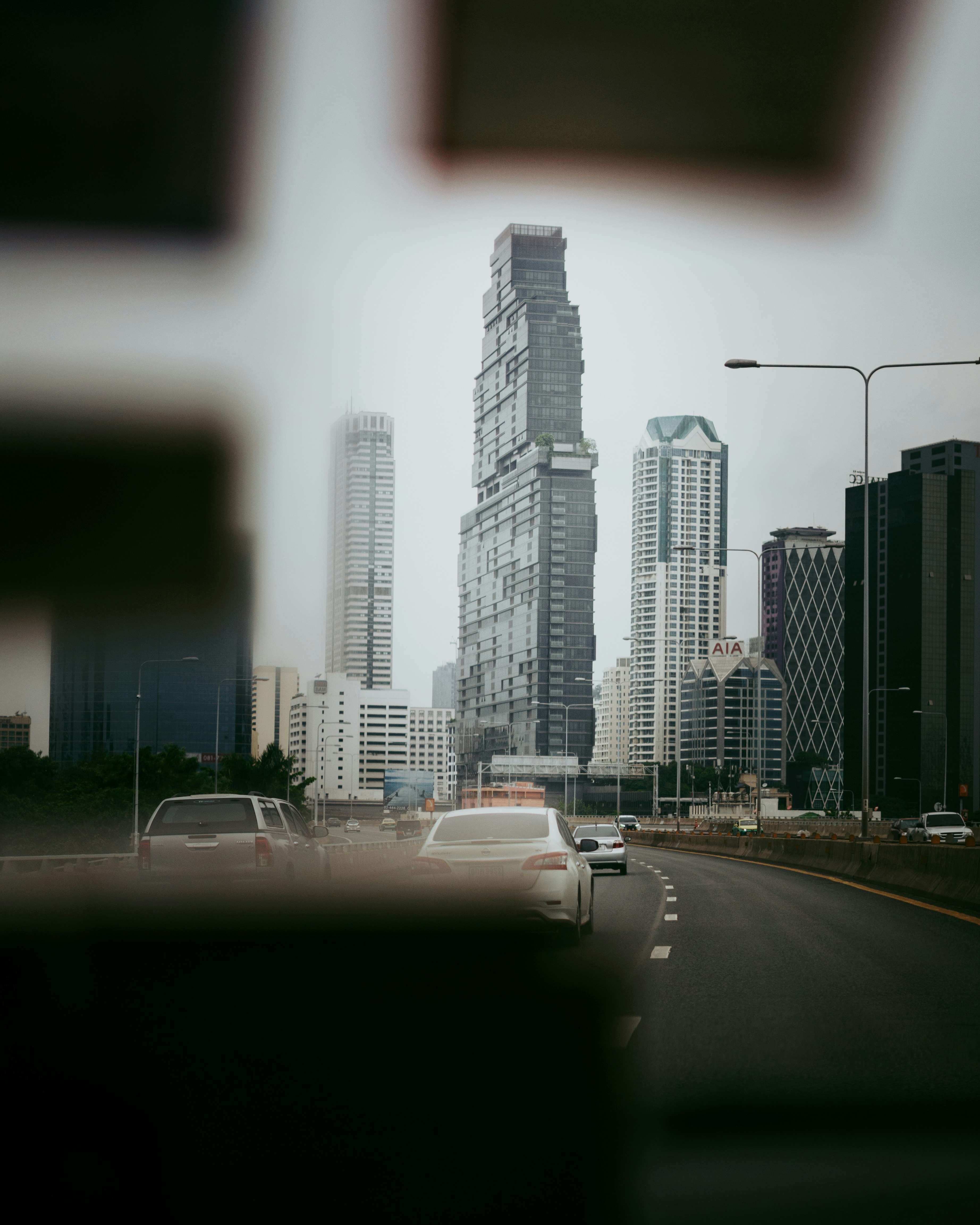 Skyline in Progress: A Tower Under Construction Framed by a Moving Highway