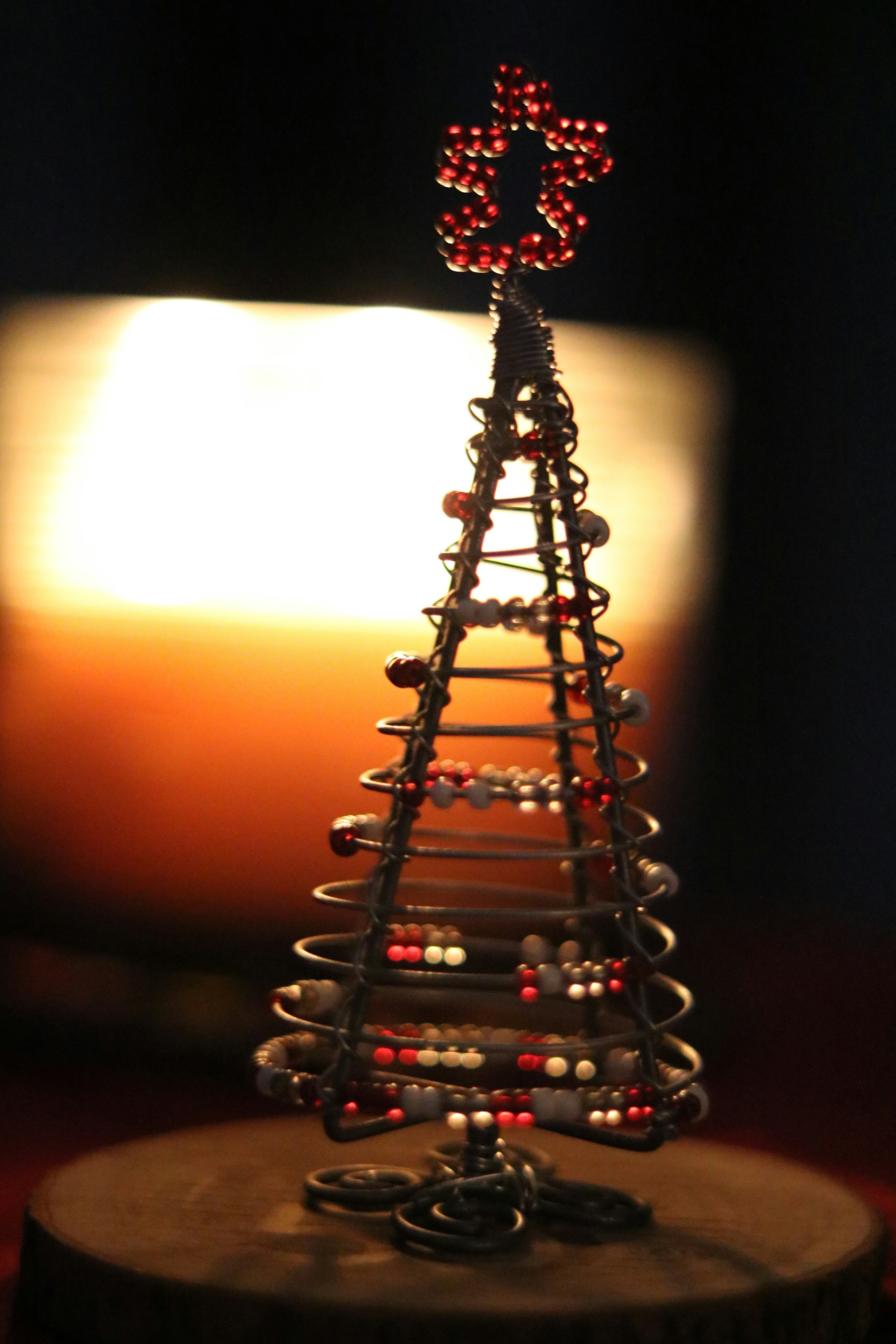 Spiraling Glow: A Tiny Wire Christmas Tree Bathed in Candlelight