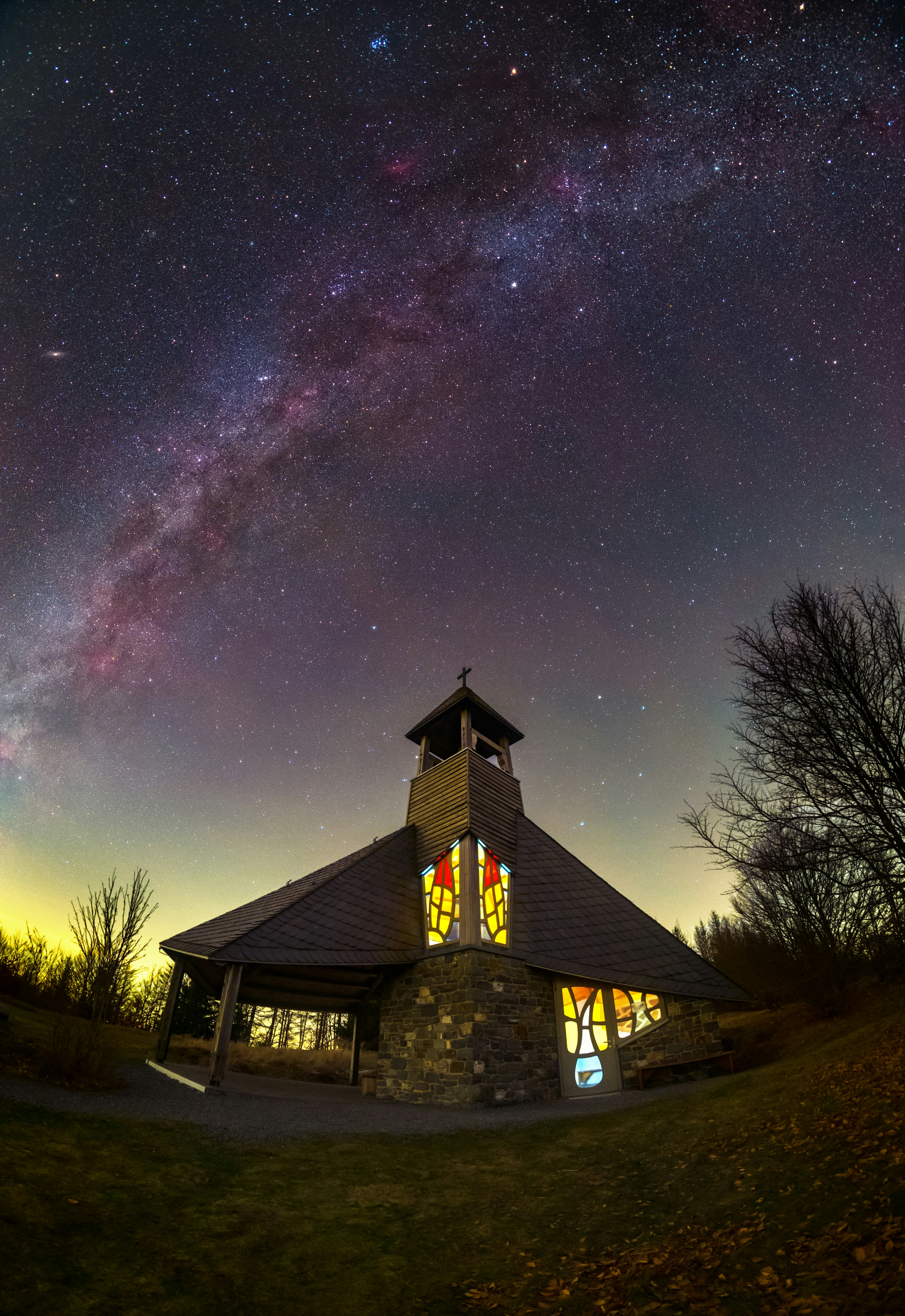 A church with a clock tower under a night sky filled with stars photo ...