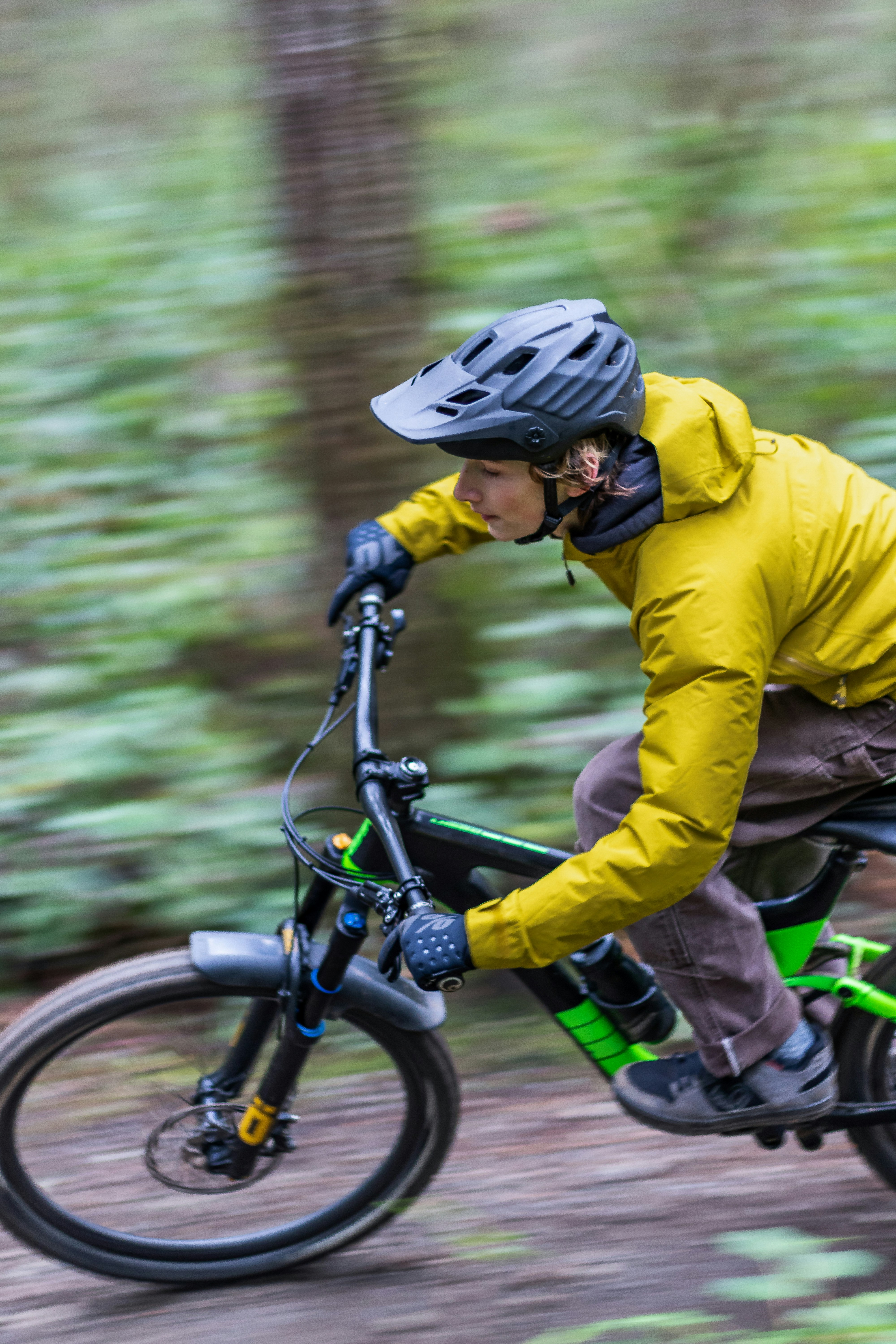Mountain biker navigating a winding trail through a lush forest, showcasing dynamic movement and adventure.