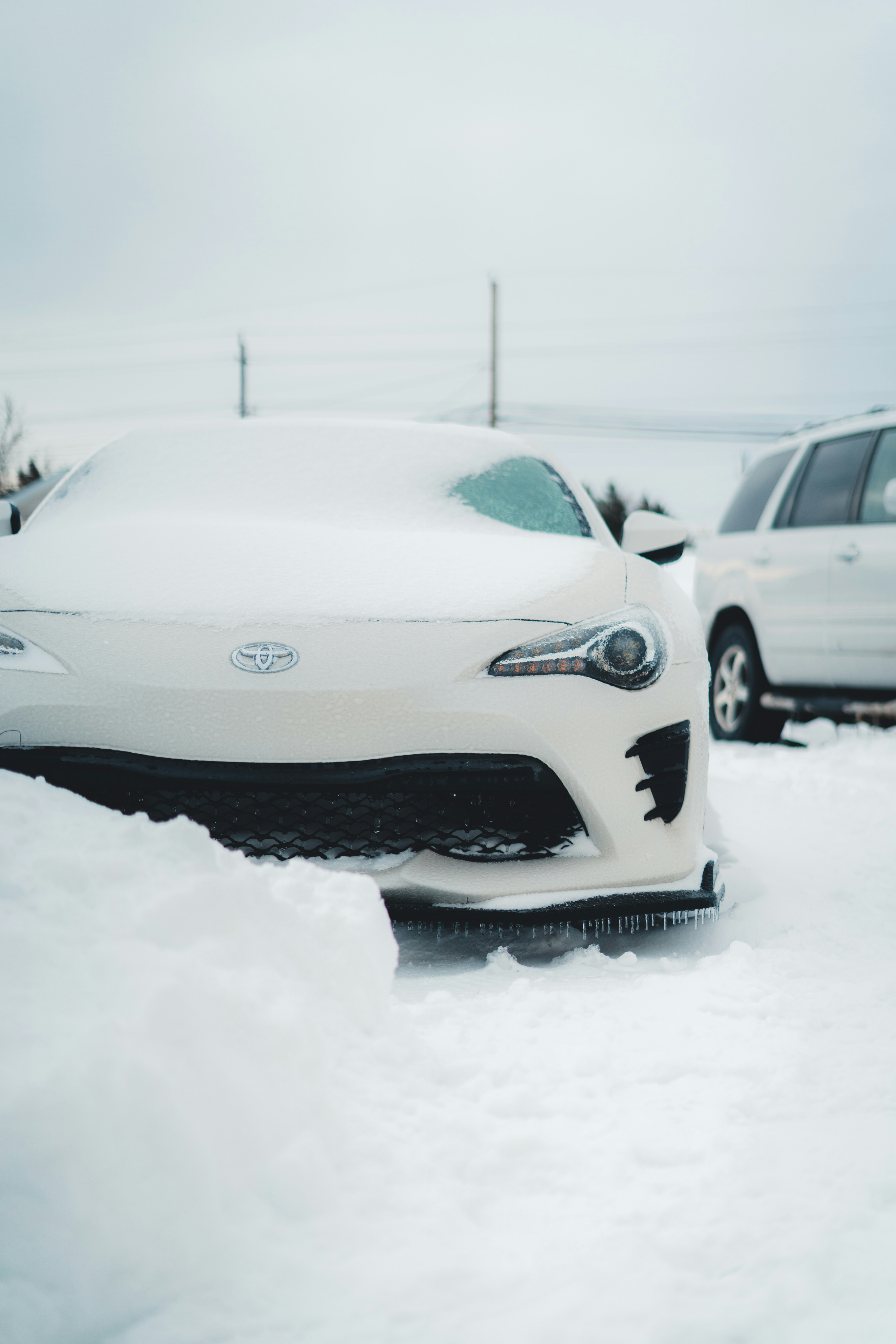 Frosted Front: Snow-Covered Toyota in a Quiet Parking Lot