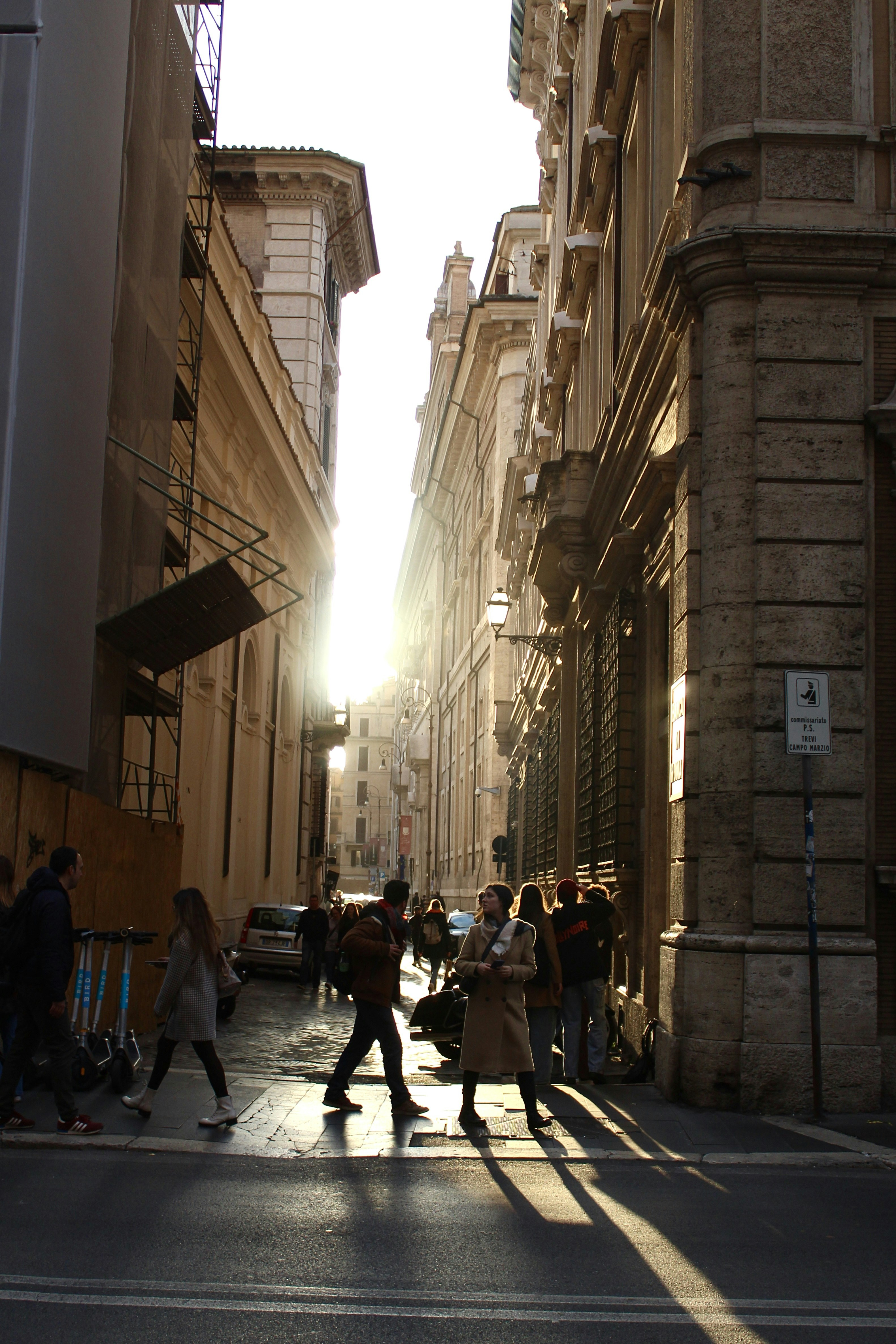 Morning Light Between Stone Facades: Footsteps in a Sunlit Alley