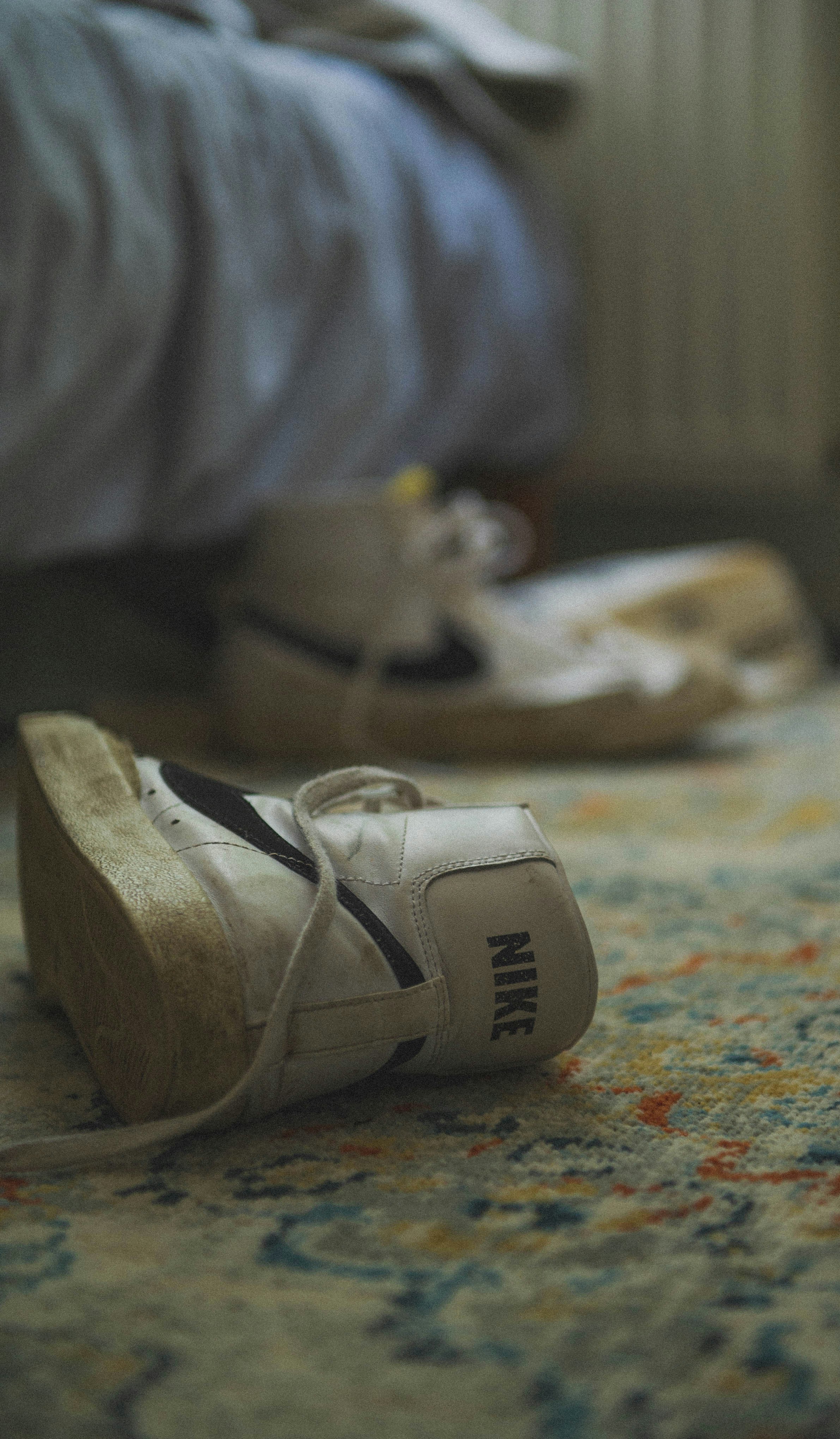 White Nike sneaker foreground with blurred bedroom setting