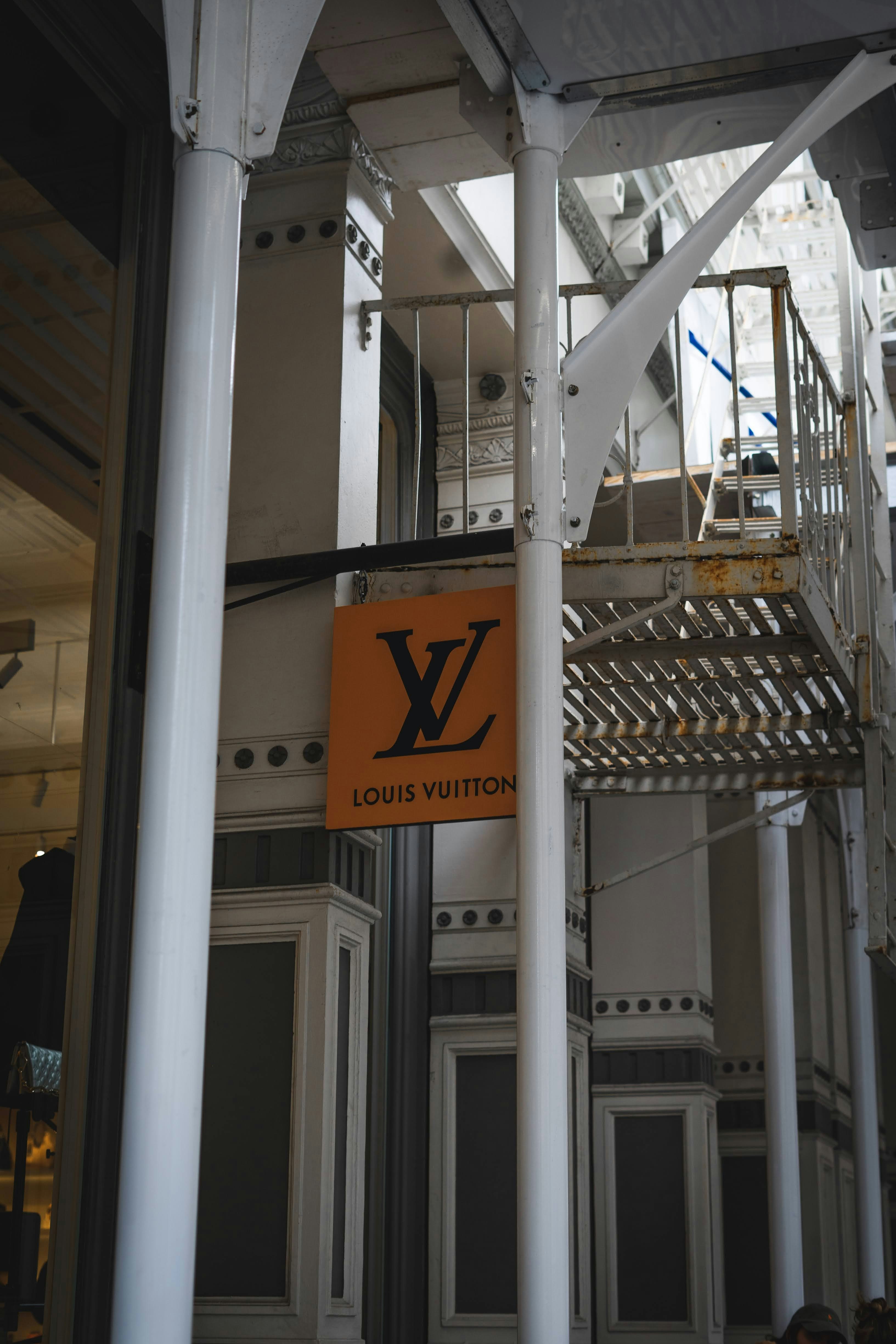 A louis vuitton sign hanging from the side of a building photo – Free ...