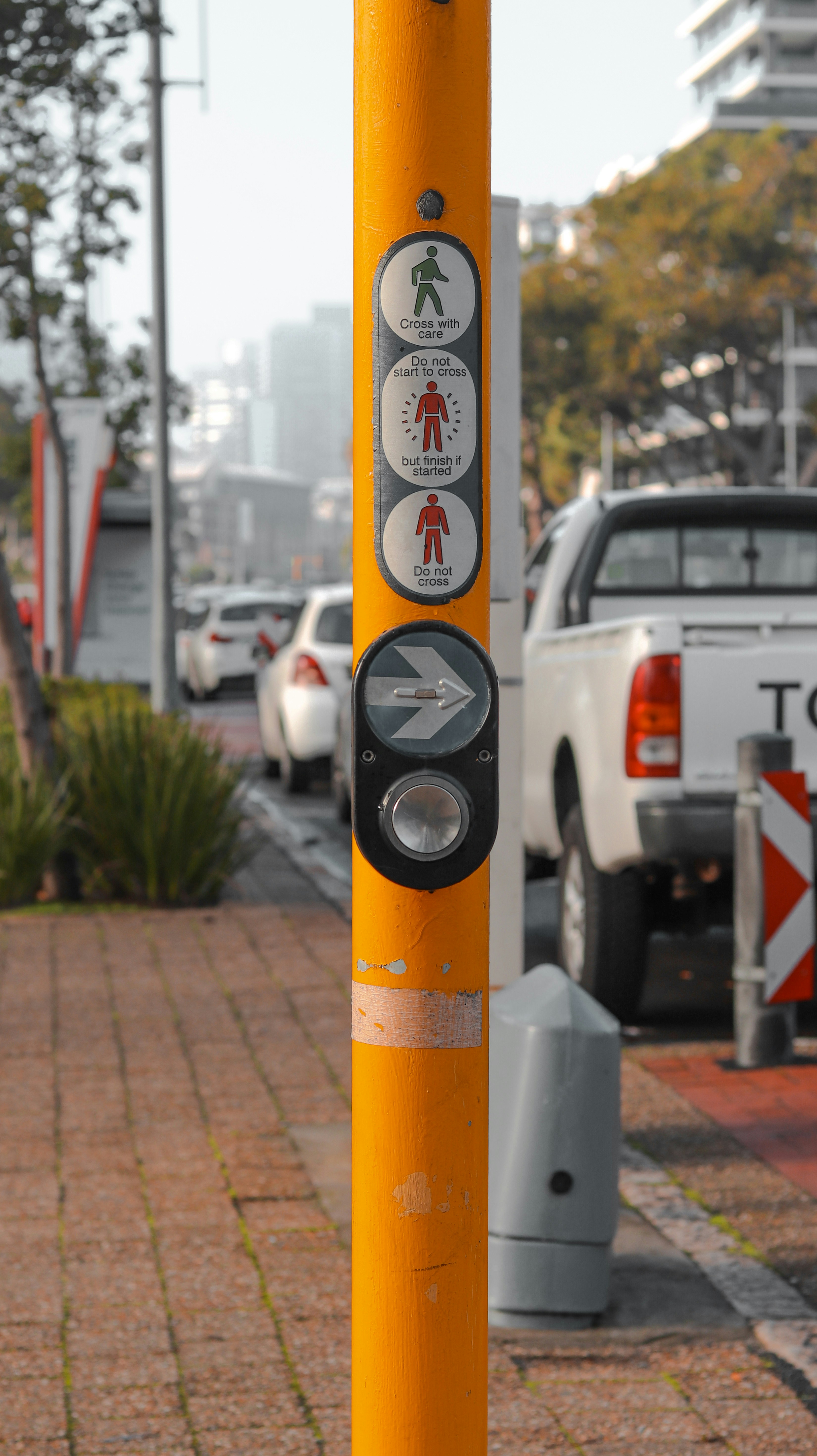 A yellow pole with several different signs on it photo – Free Cape town ...