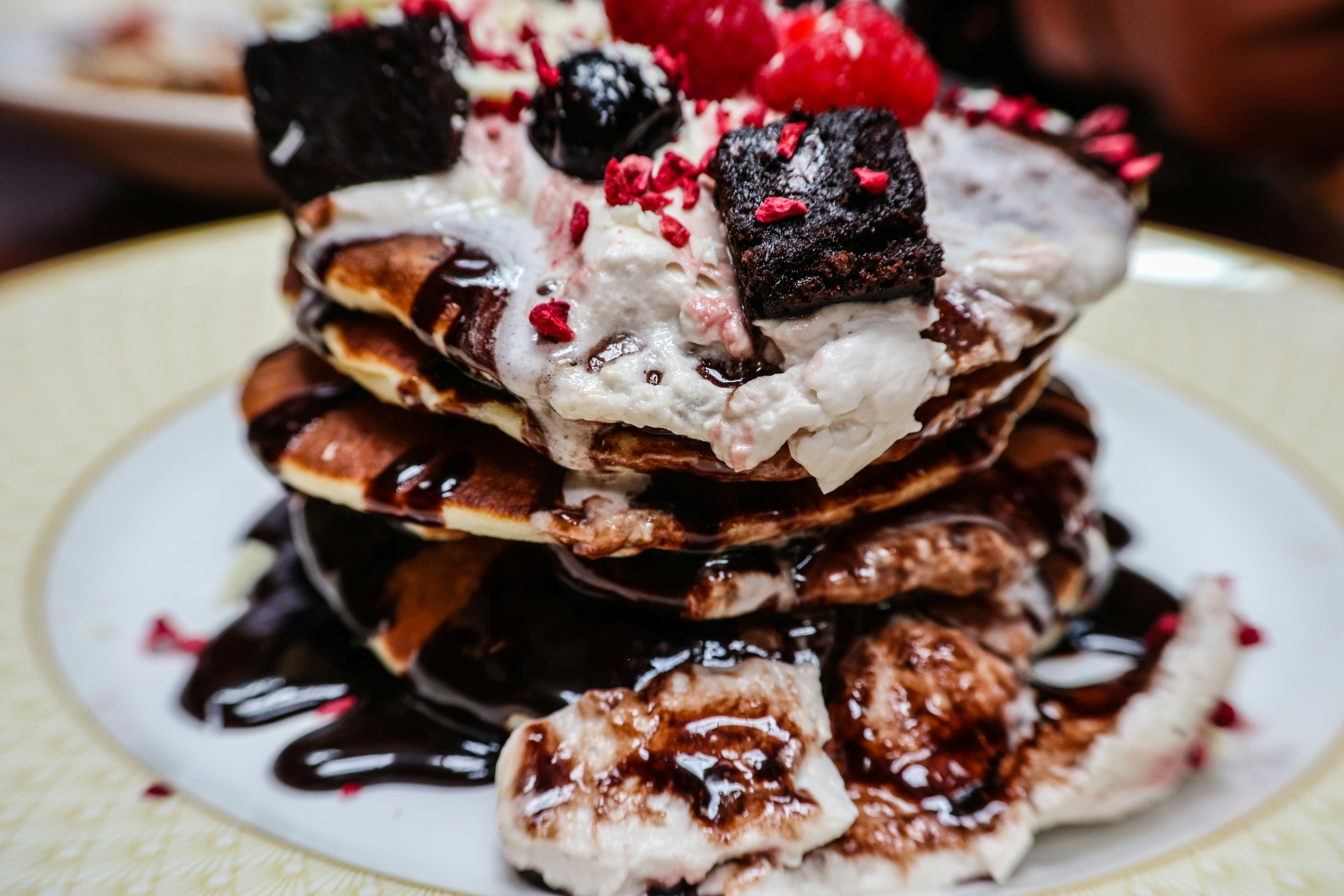 A stack of pancakes covered in whipped cream and toppings photo – Free ...