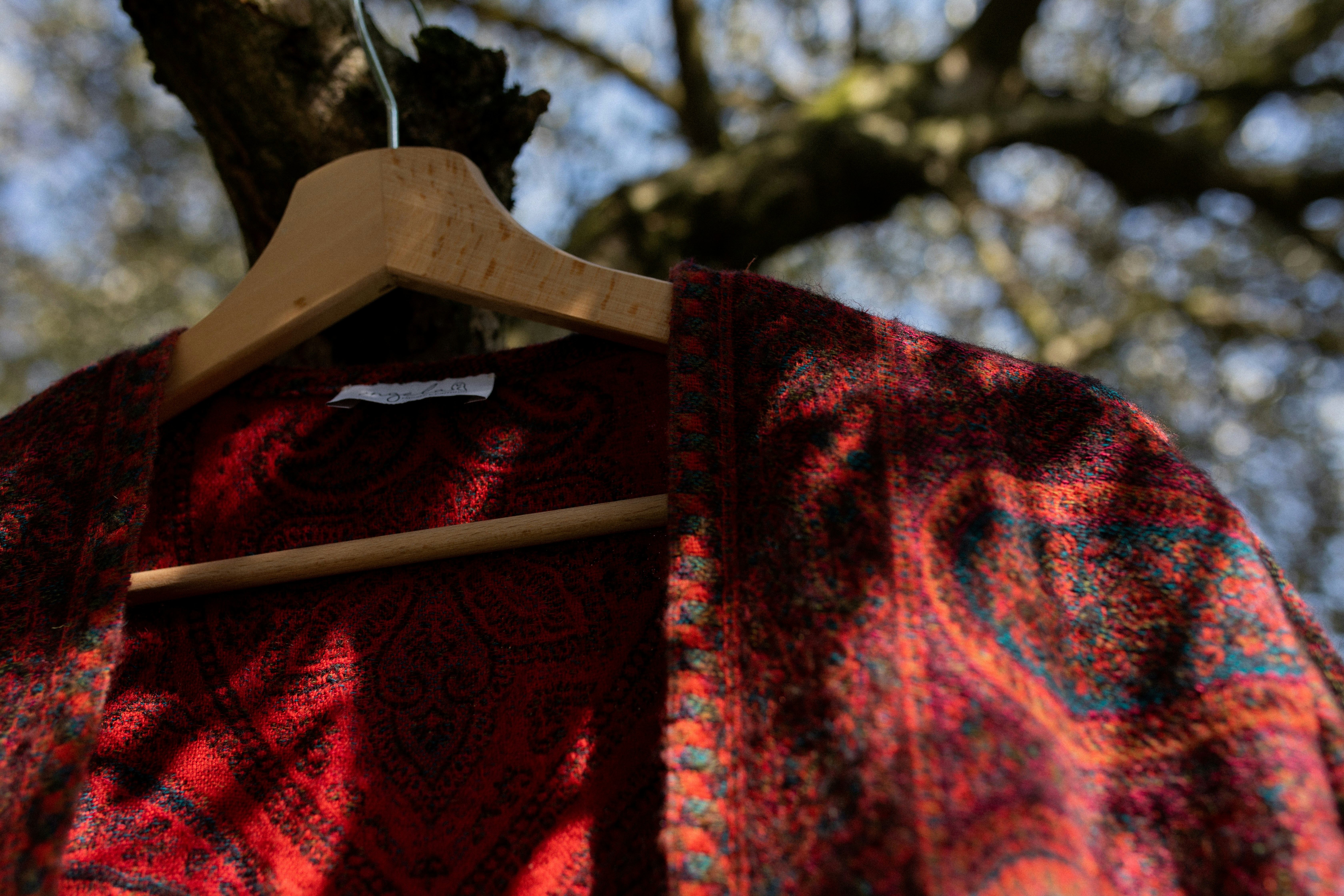 Hanging Pattern: A Cozy Red Garment Draped in Dappled Light