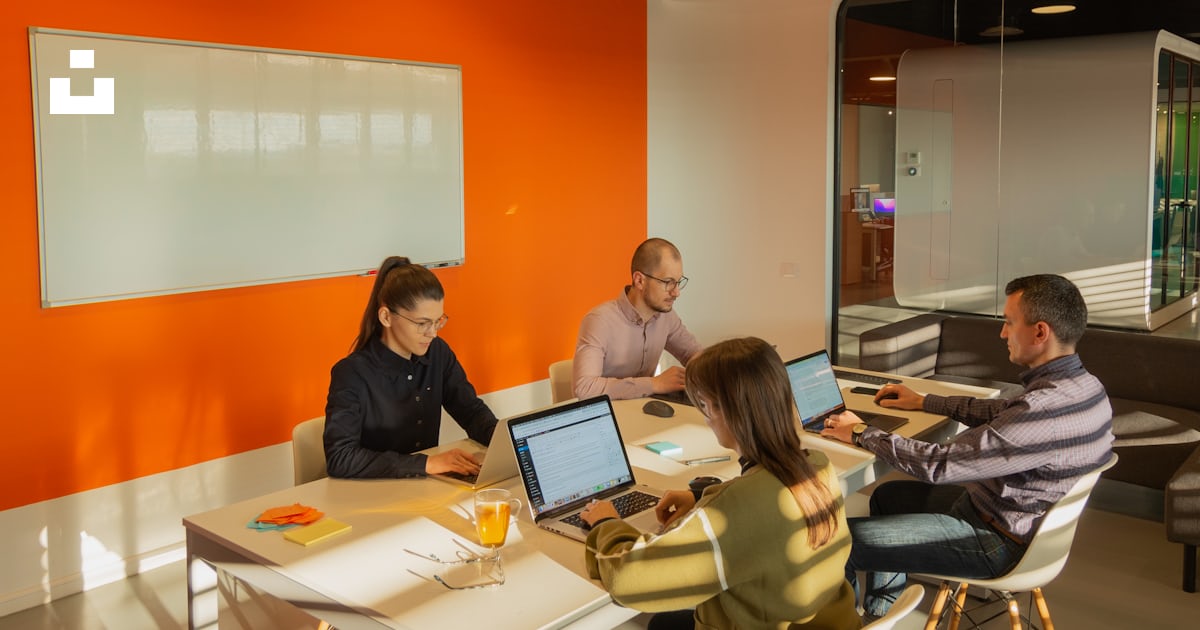 Un Groupe De Personnes Assises Autour Dune Table Avec Des Ordinateurs