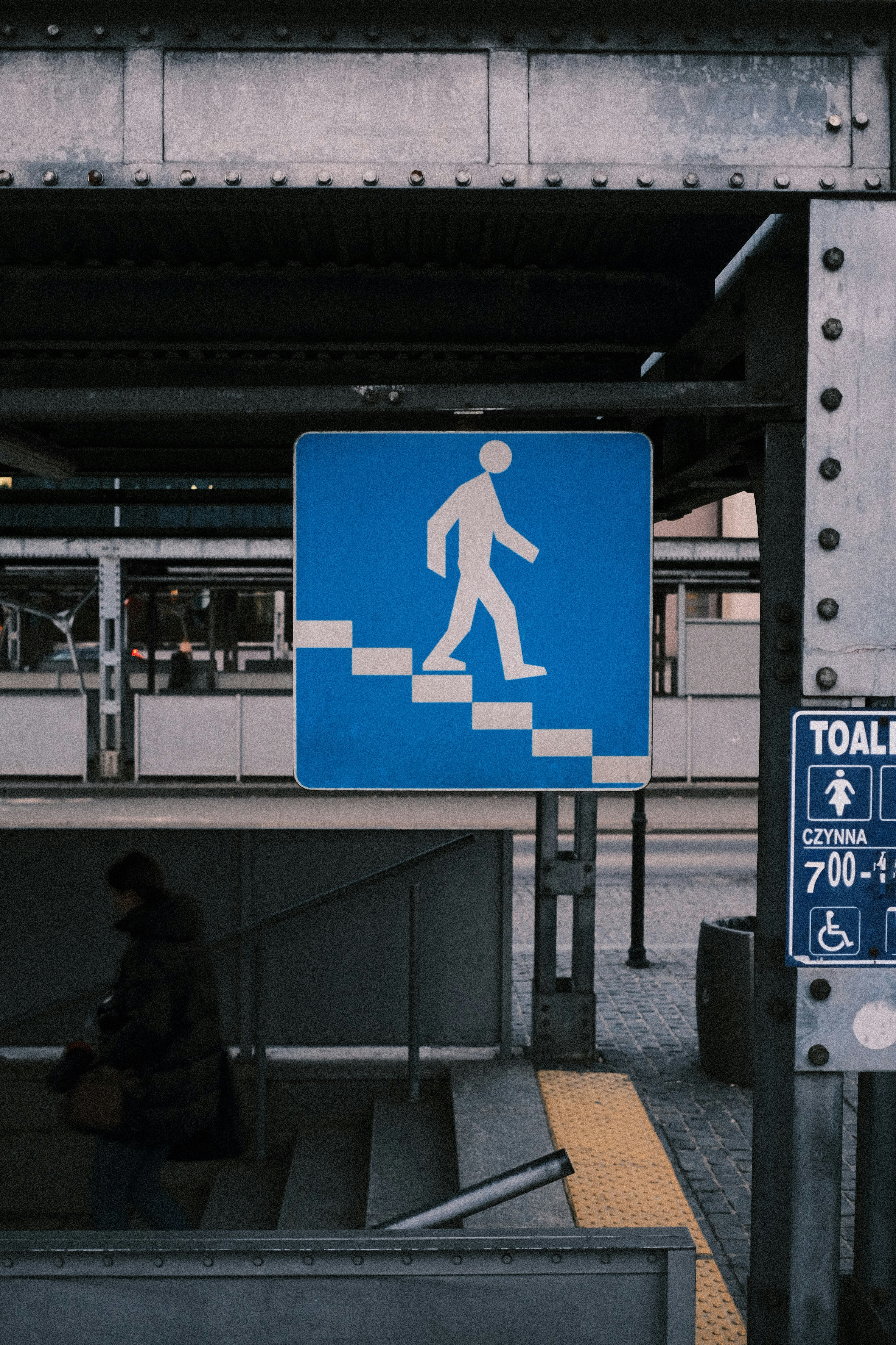 A blue sign with a man walking up a flight of stairs photo – Free ...