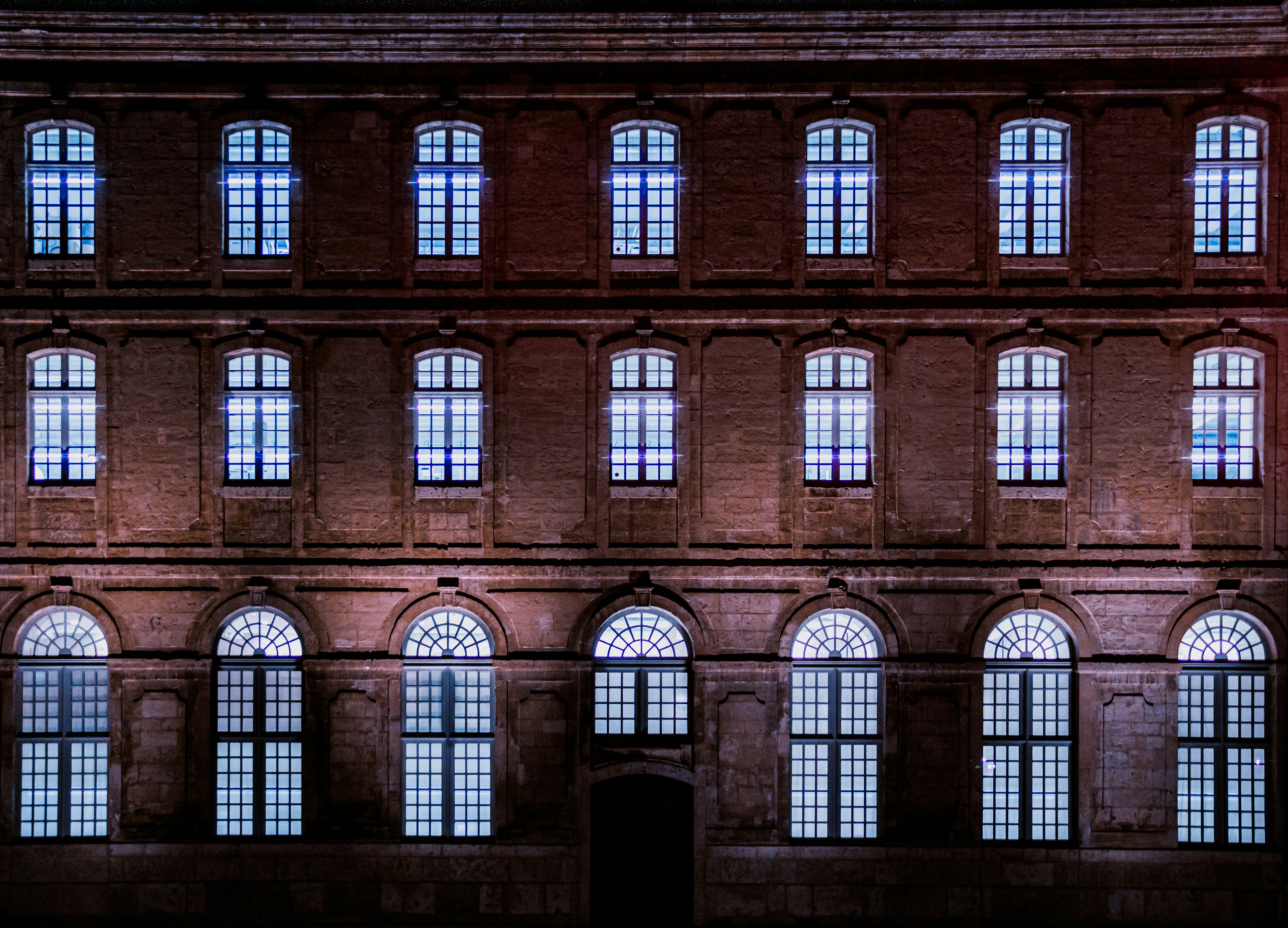 A large building with many windows lit up at night photo – Free Pattern ...