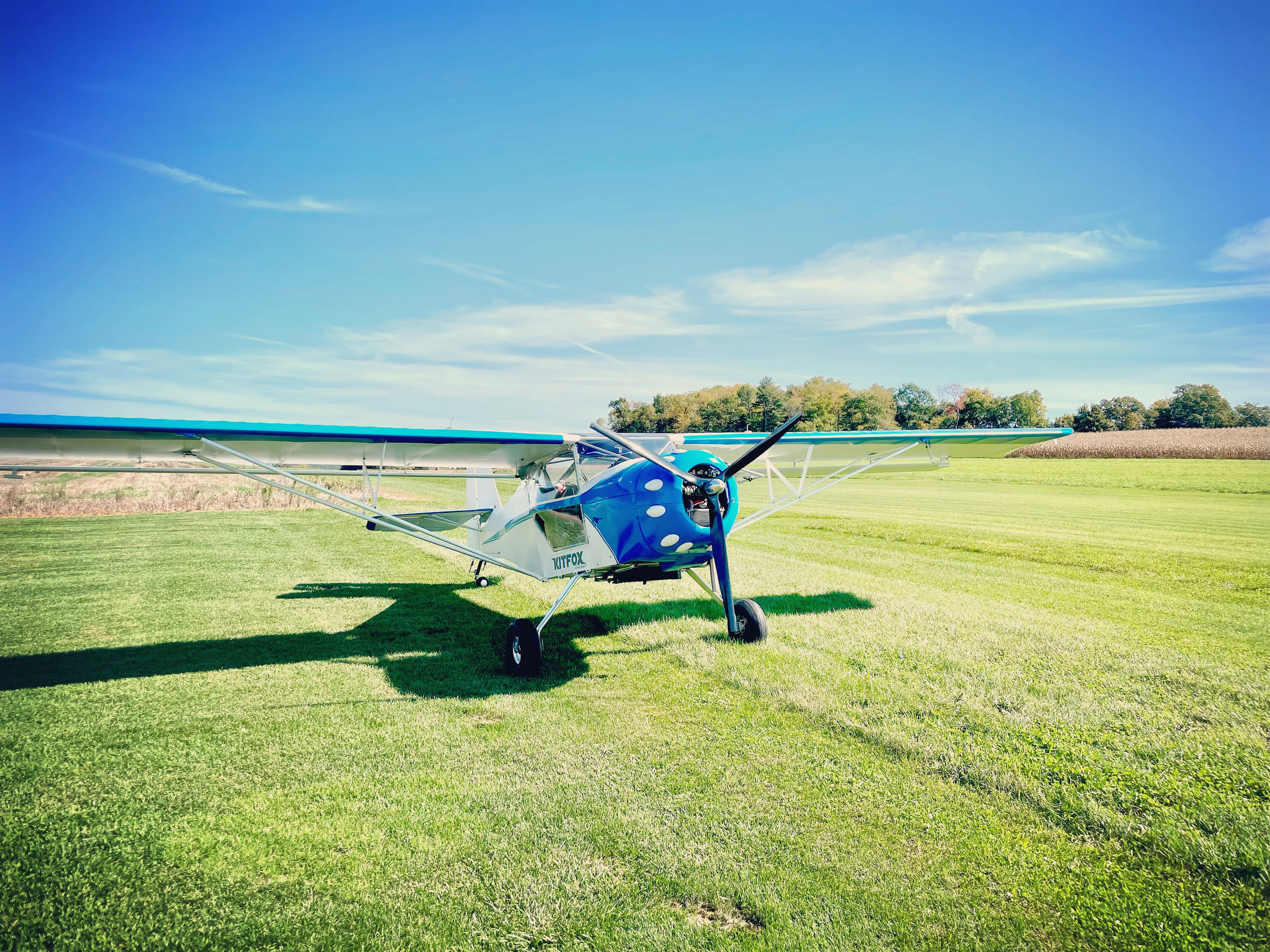 a small airplane sitting on top of a lush green field