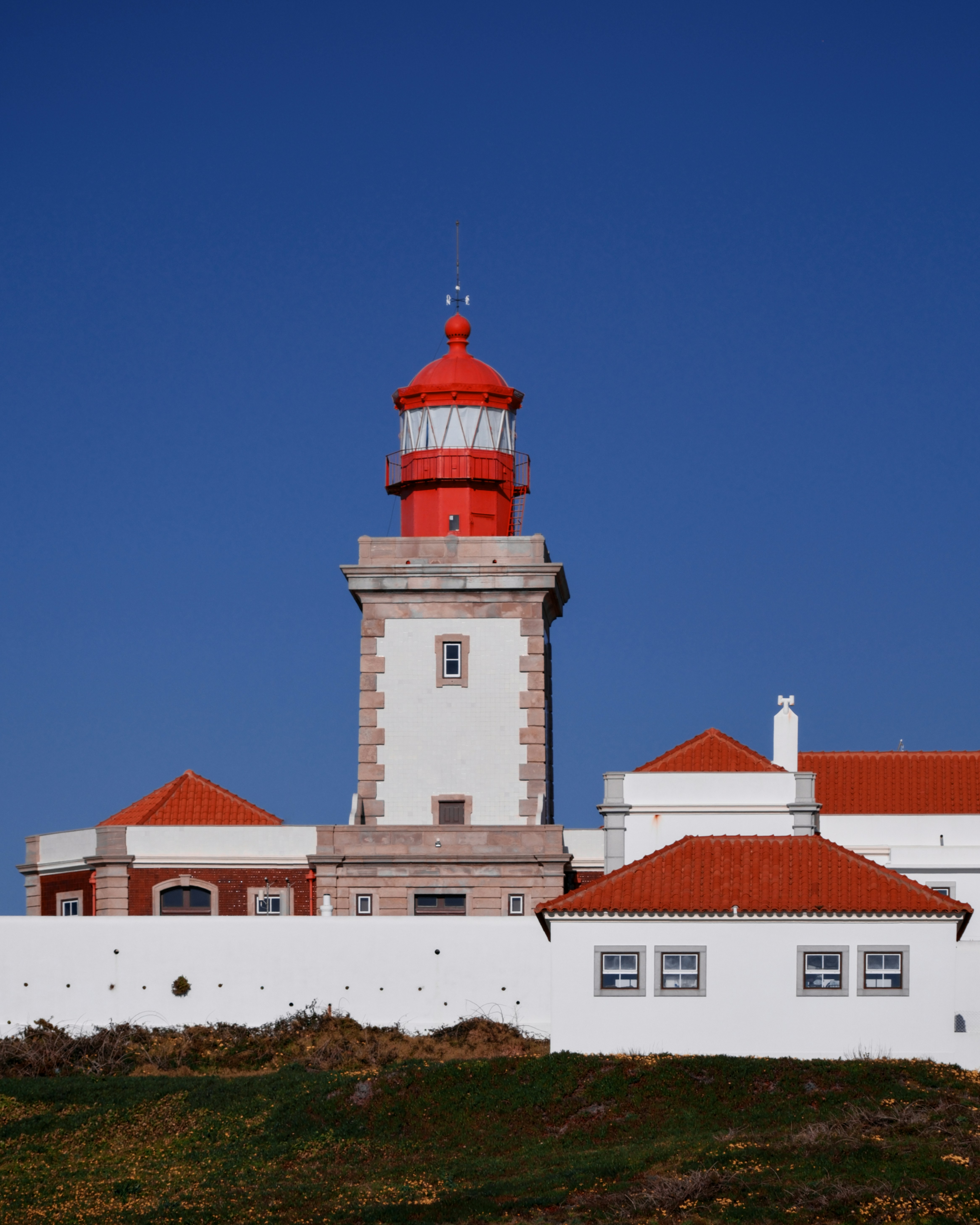 a red and white lighthouse on top of a hill