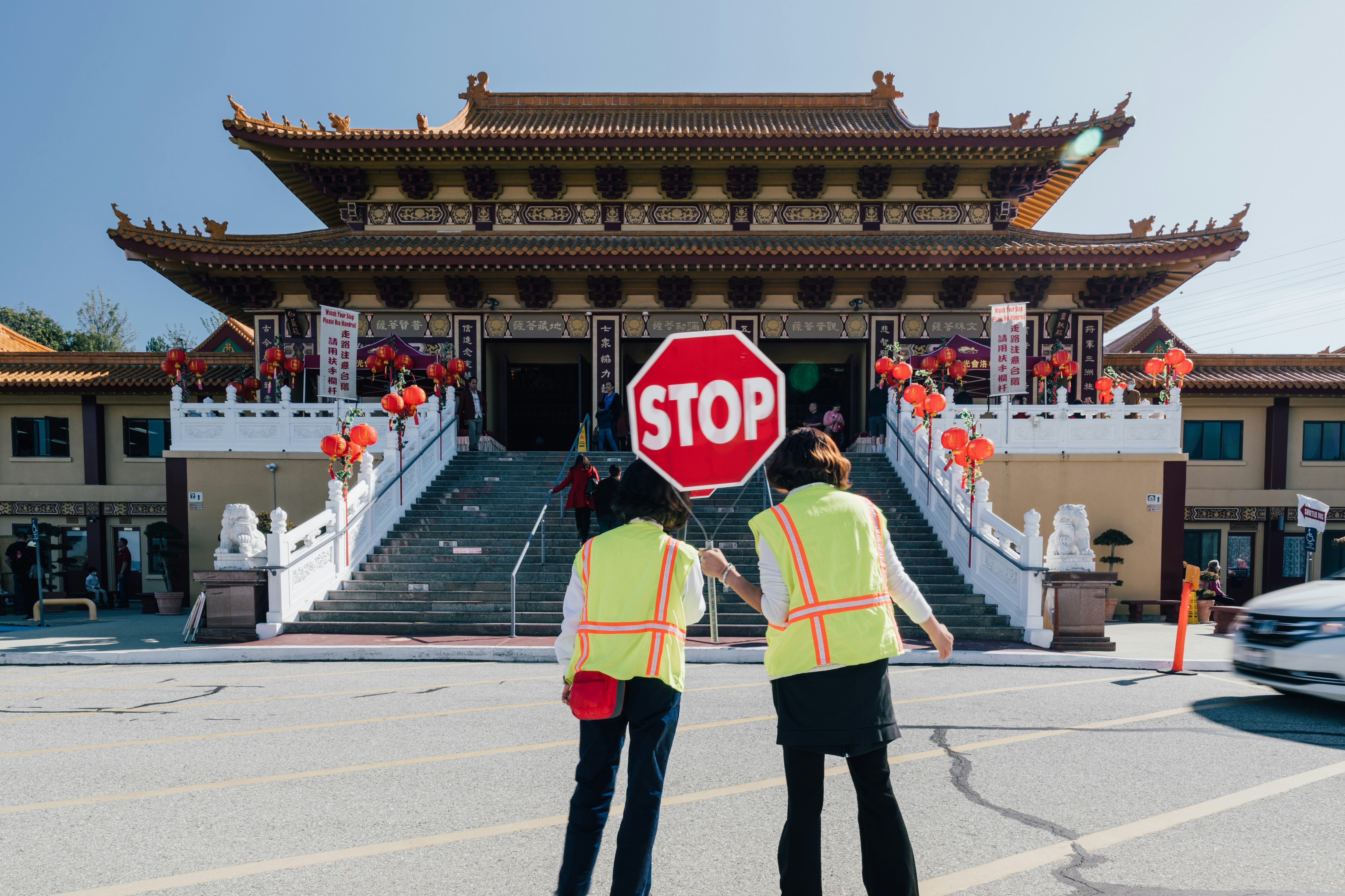 A couple of men standing next to a stop sign photo – Free Street Image ...